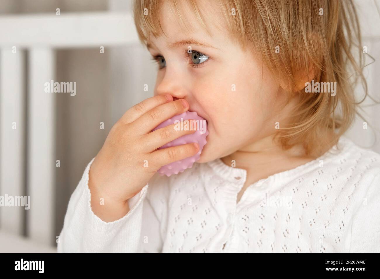 Cute baby girl playing tactile wooden and silicone toys. Young child ...