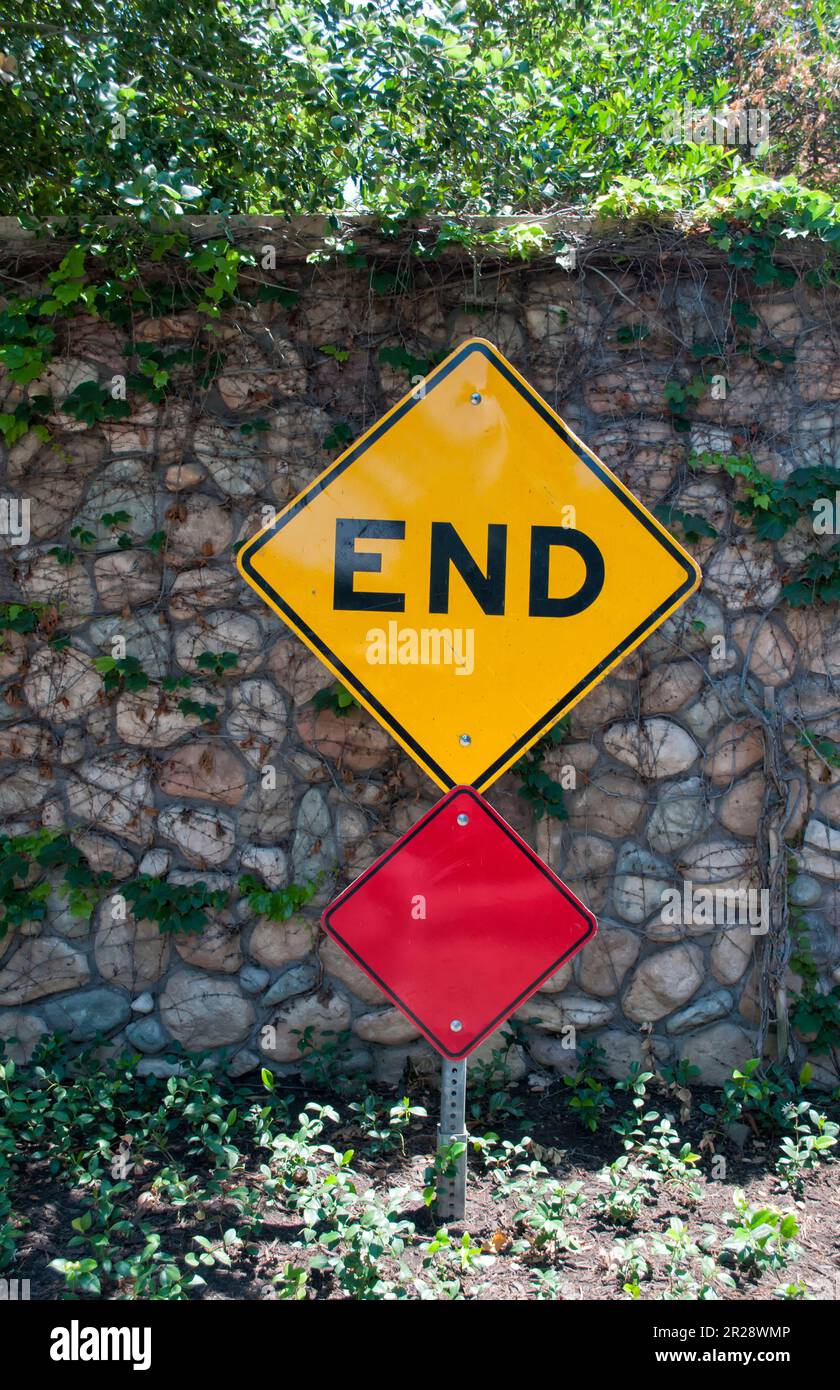 End road sign against stone wall Stock Photo - Alamy