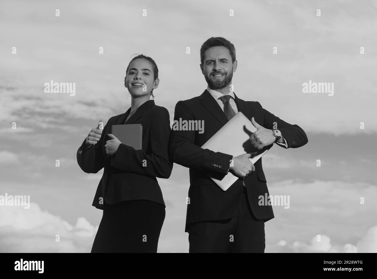 Portrait of business couple in suit with thumbs up. Two young business ...