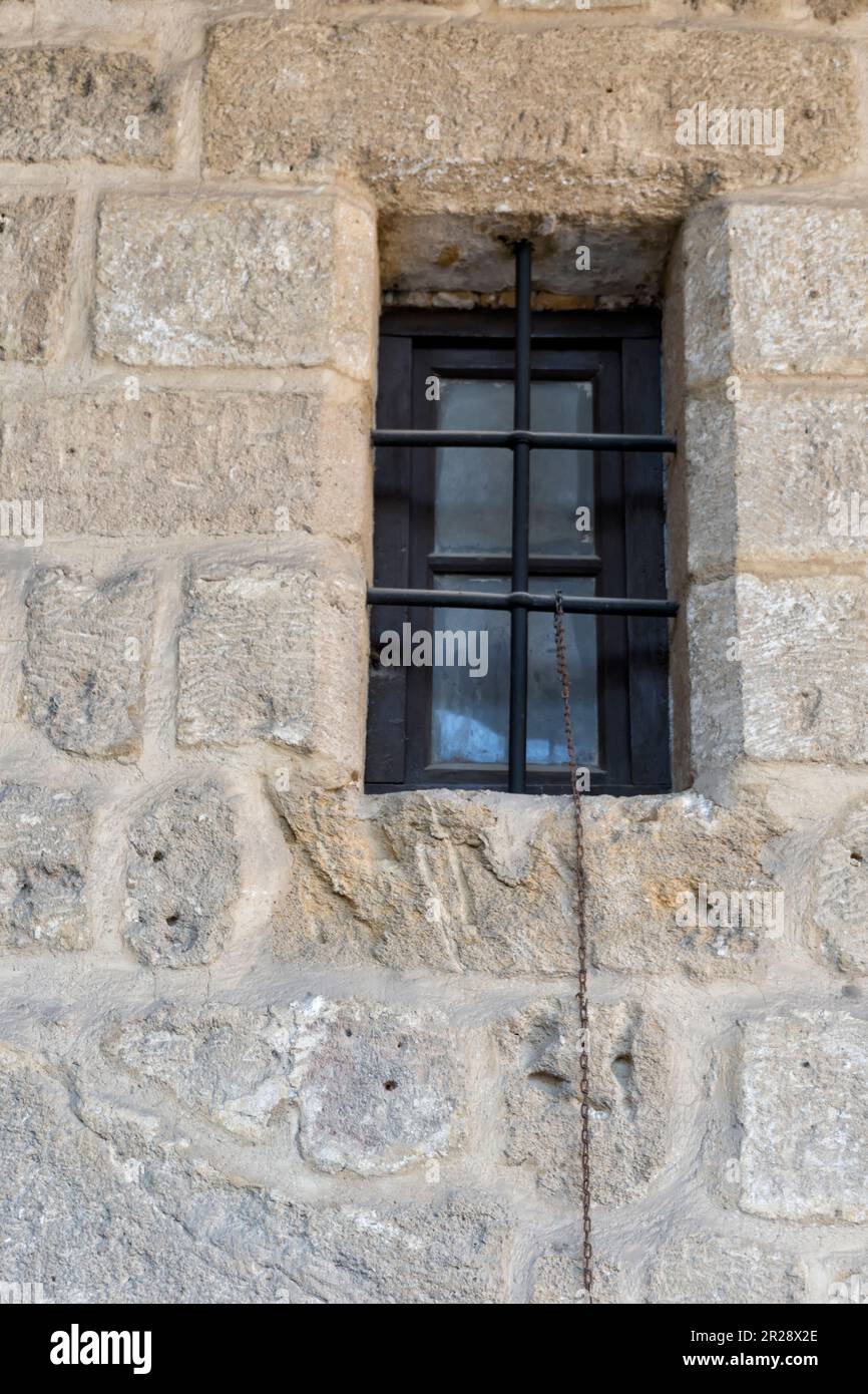 A window with iron bars in old stone wall of Buyuk Han (Great Inn) in ...