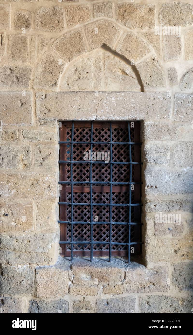 An old Ottoman style window with iron bars in old stone wall of Buyuk ...