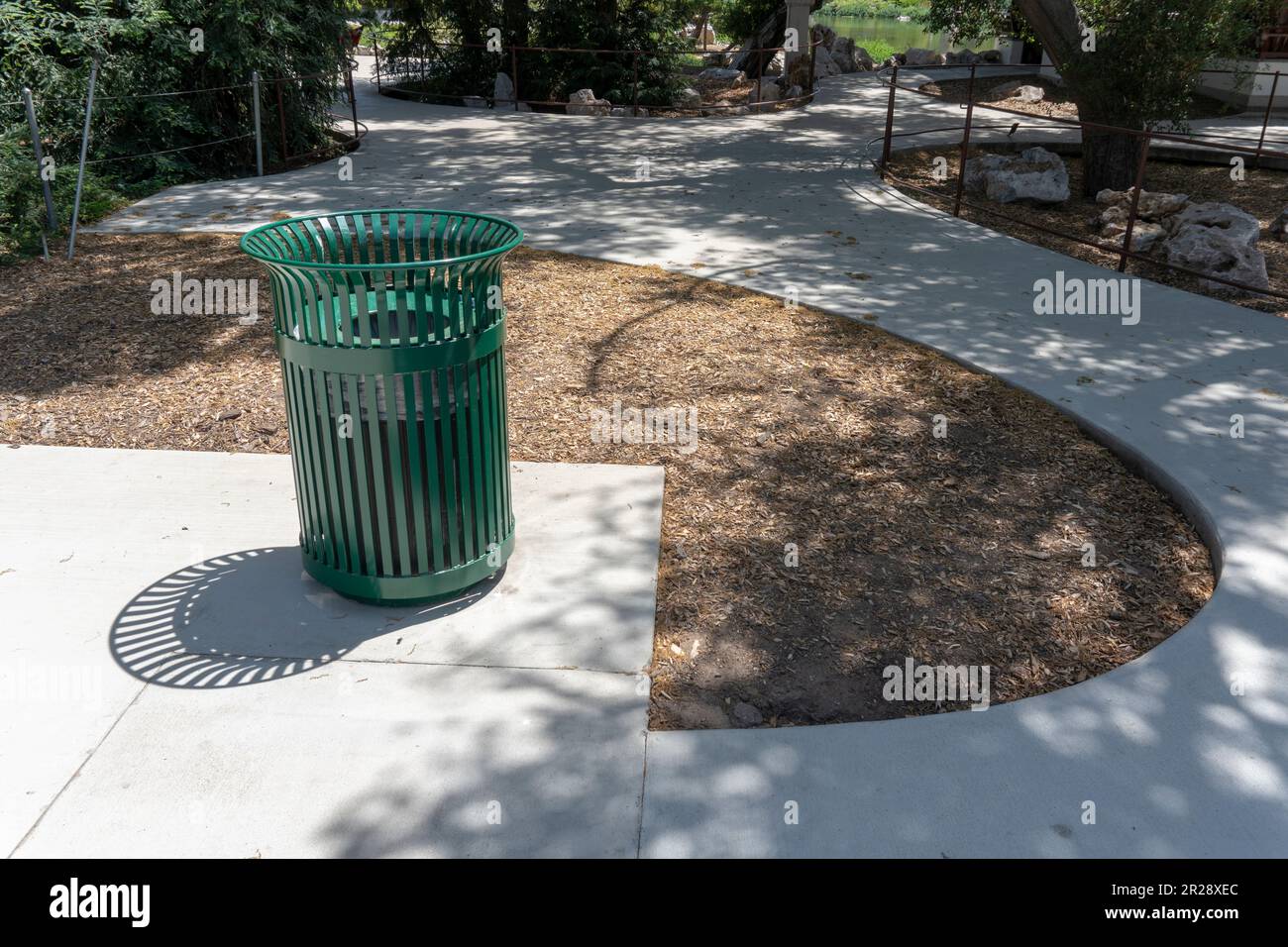 A green trash can in the park, sunny day Stock Photo - Alamy