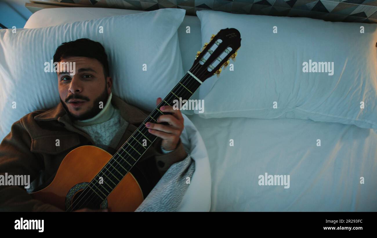 Man sing and Play the guitar in a bed Stock Photo - Alamy