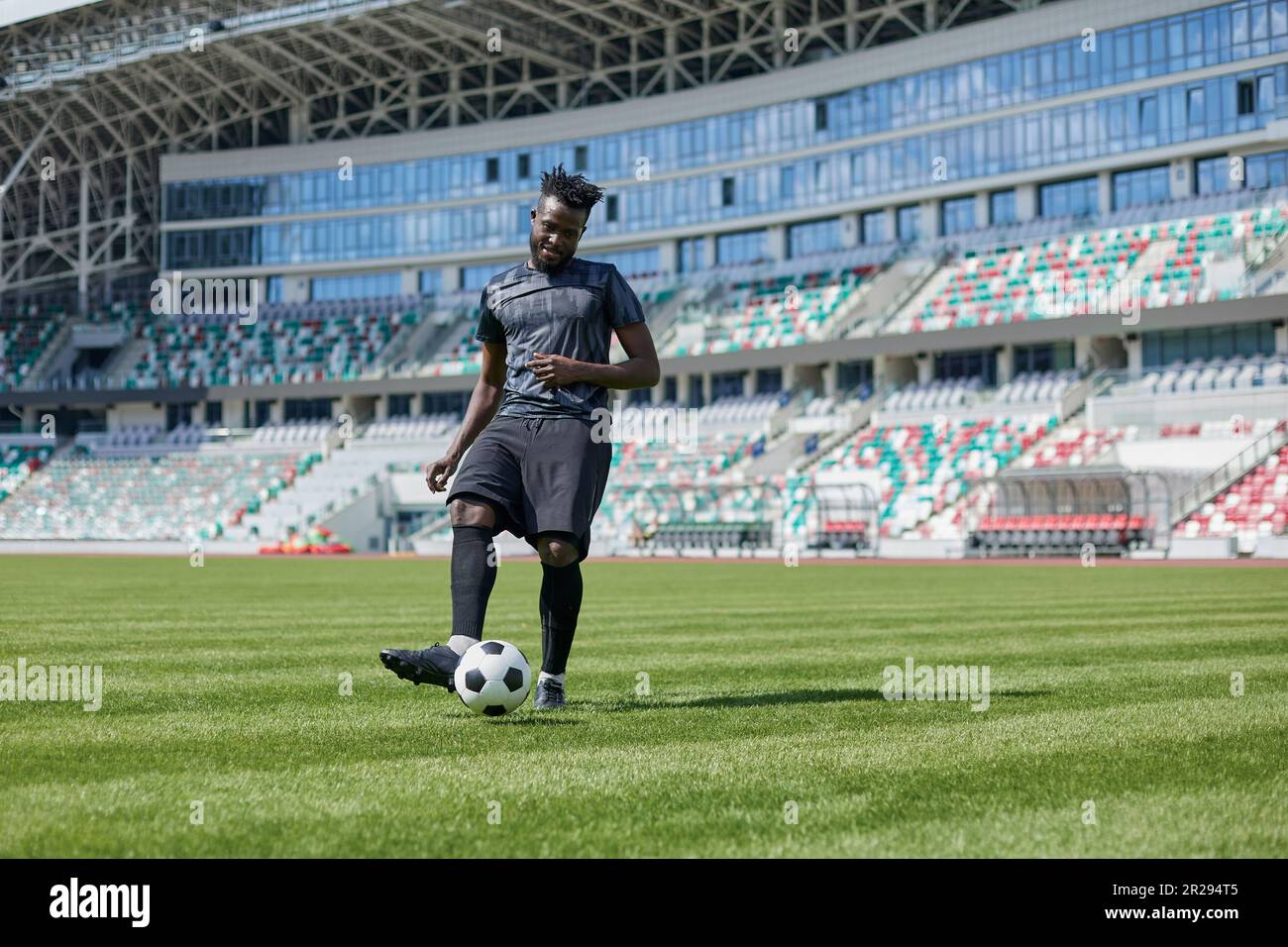 African American man playing football on the stadium field Stock Photo ...