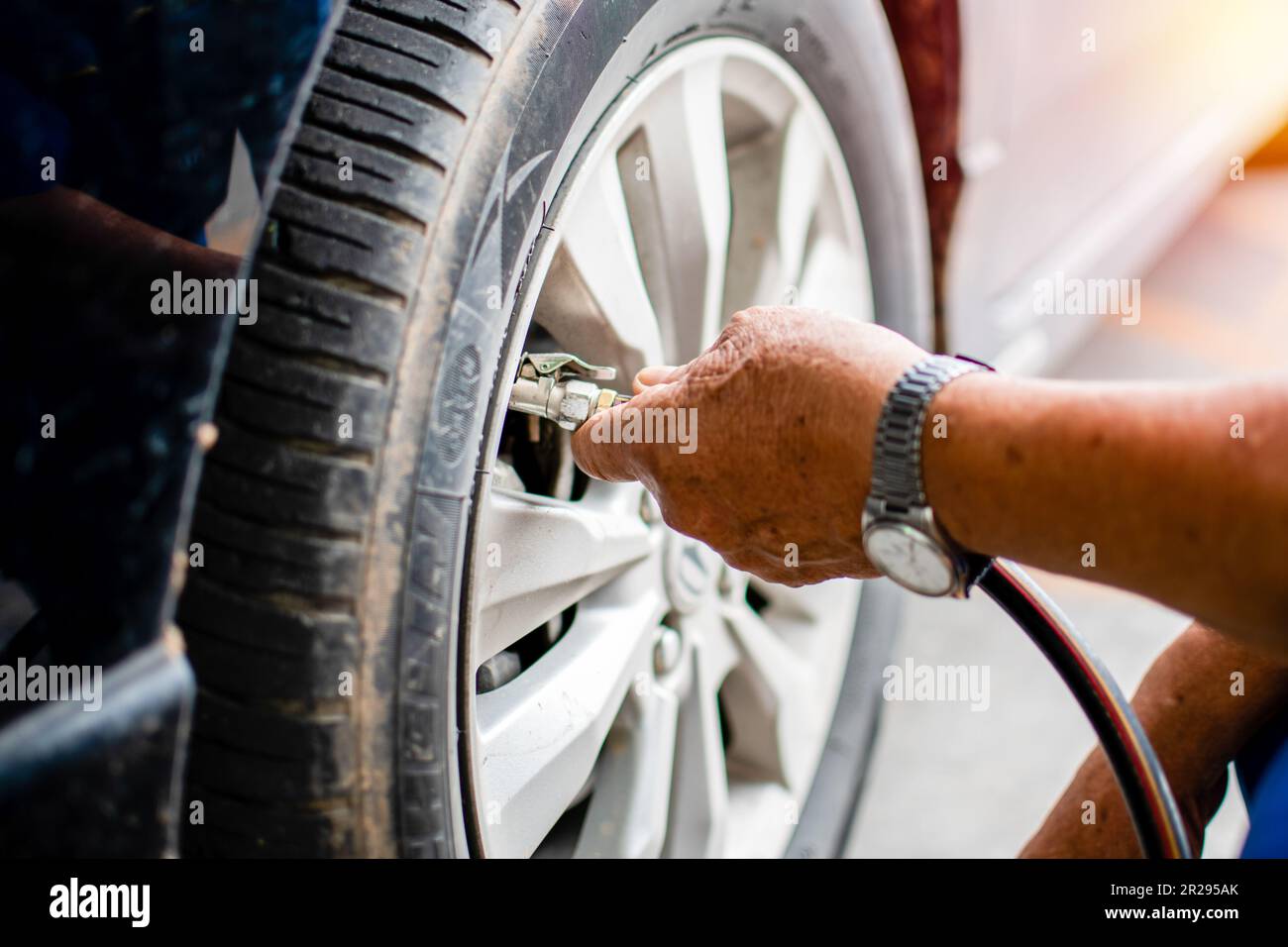 Hand of a young male holding the pipe to checking air pressure and ...