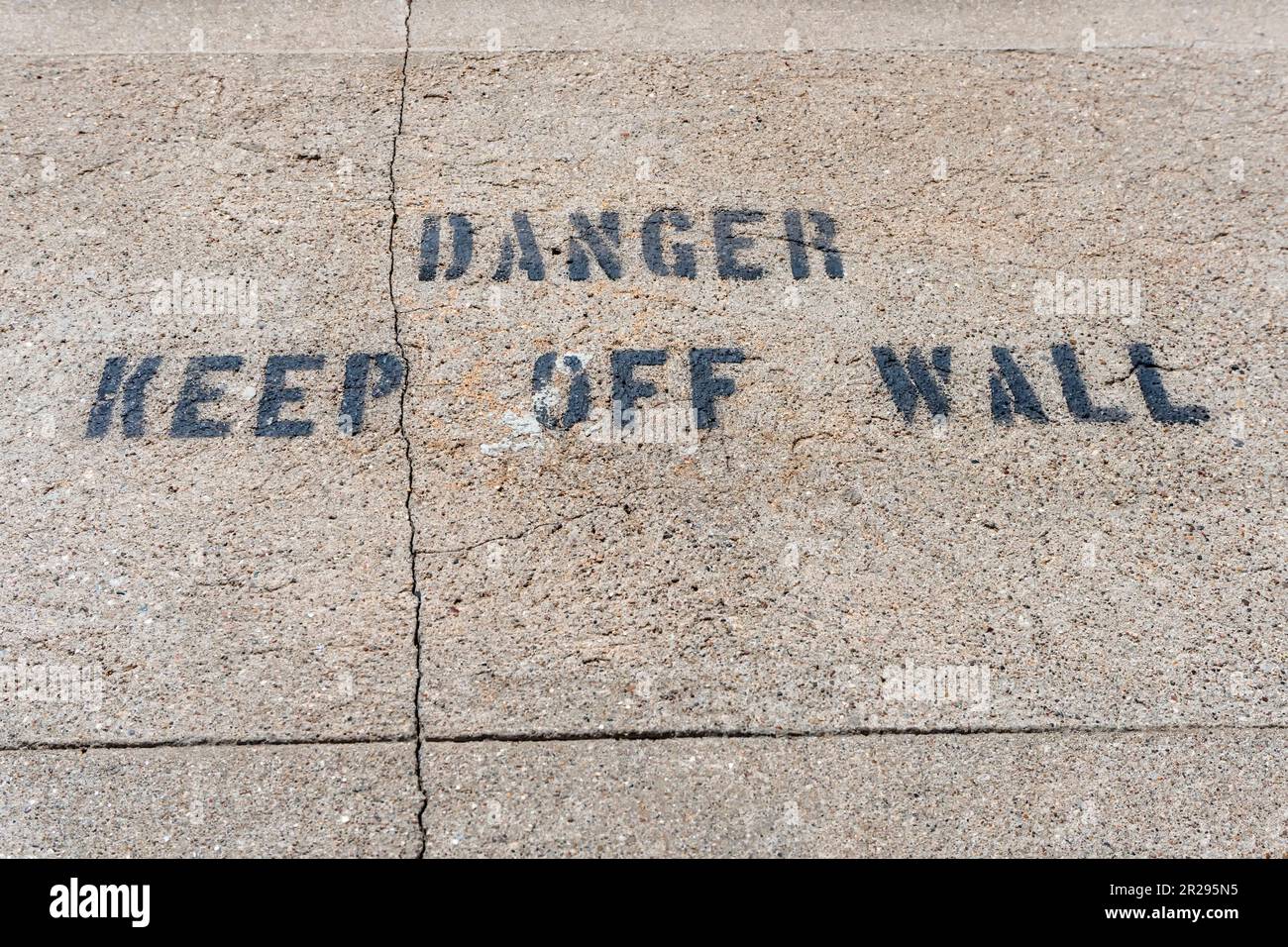 Danger keep off wall text on cracked concrete wall Stock Photo - Alamy