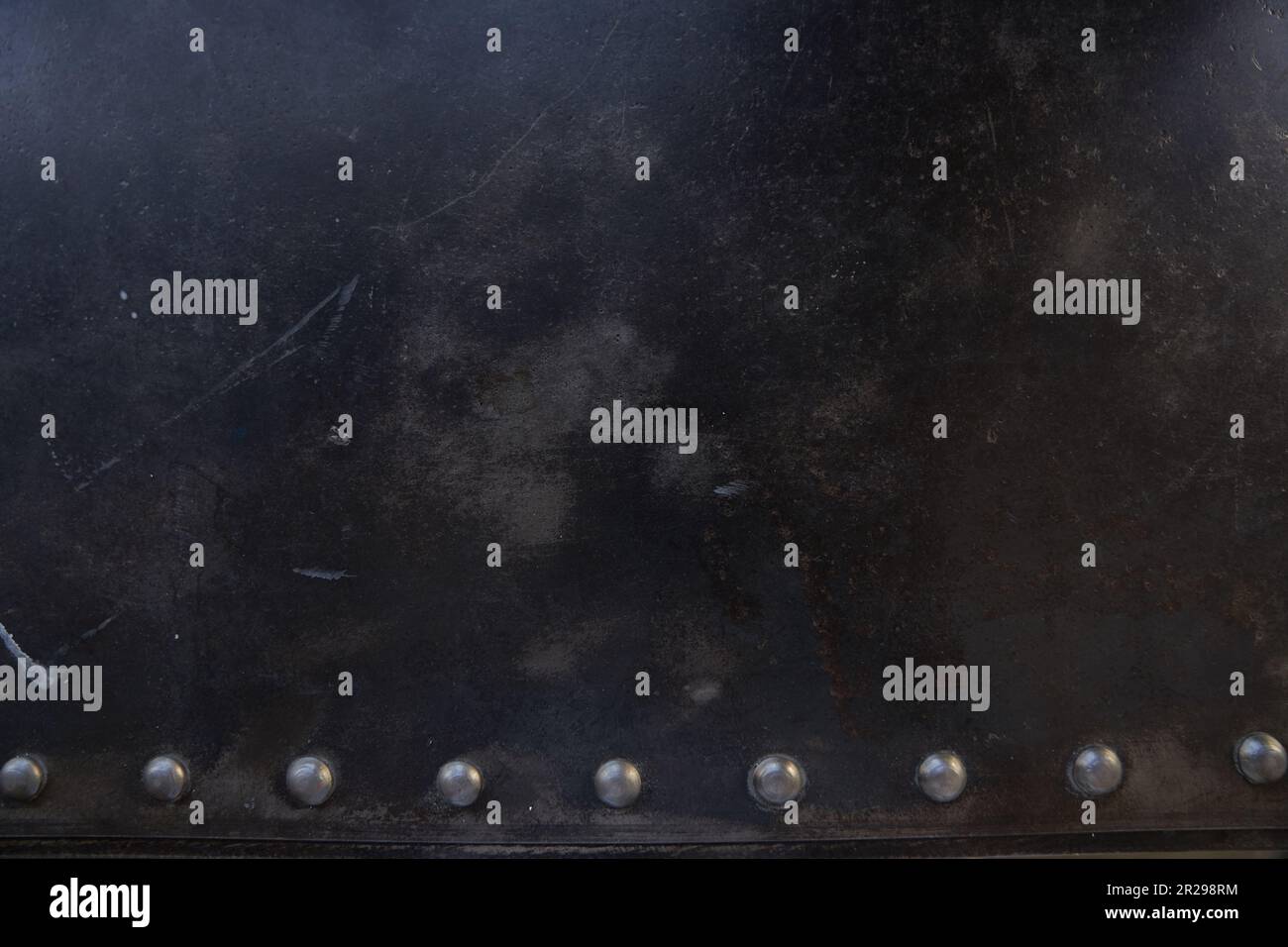 Metal rivets in a row on the scratched surface of the leather material ...