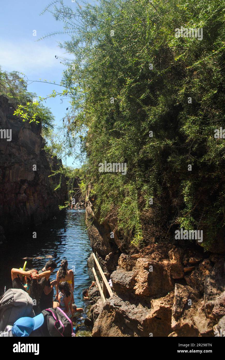 People in Las Grietas, an ocean water pool positioned between two tall ...