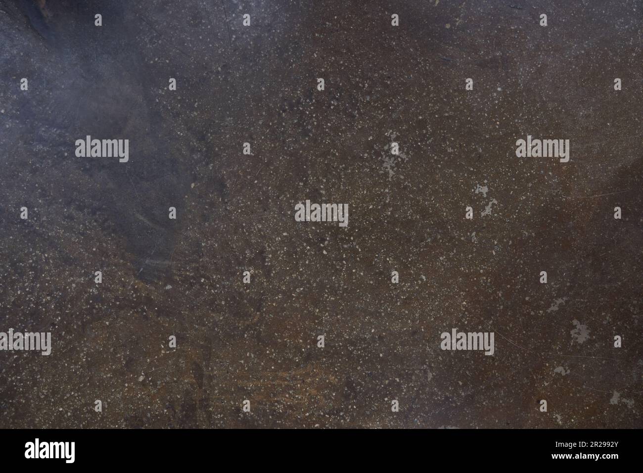 Dark scuffed surface of a stone slab. Rough texture of brown stone or ...