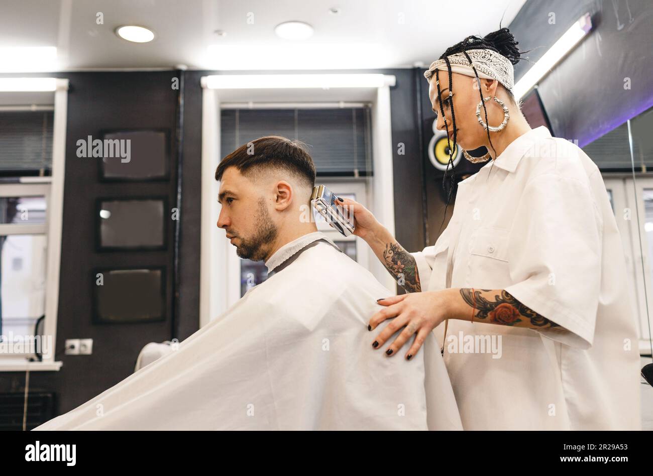 A barber cuts a man's hair in a barber shop. Men's professional hair ...