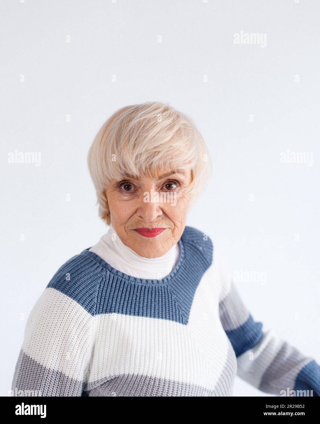 Studio portrait of an older woman. An older model with short gray hair ...