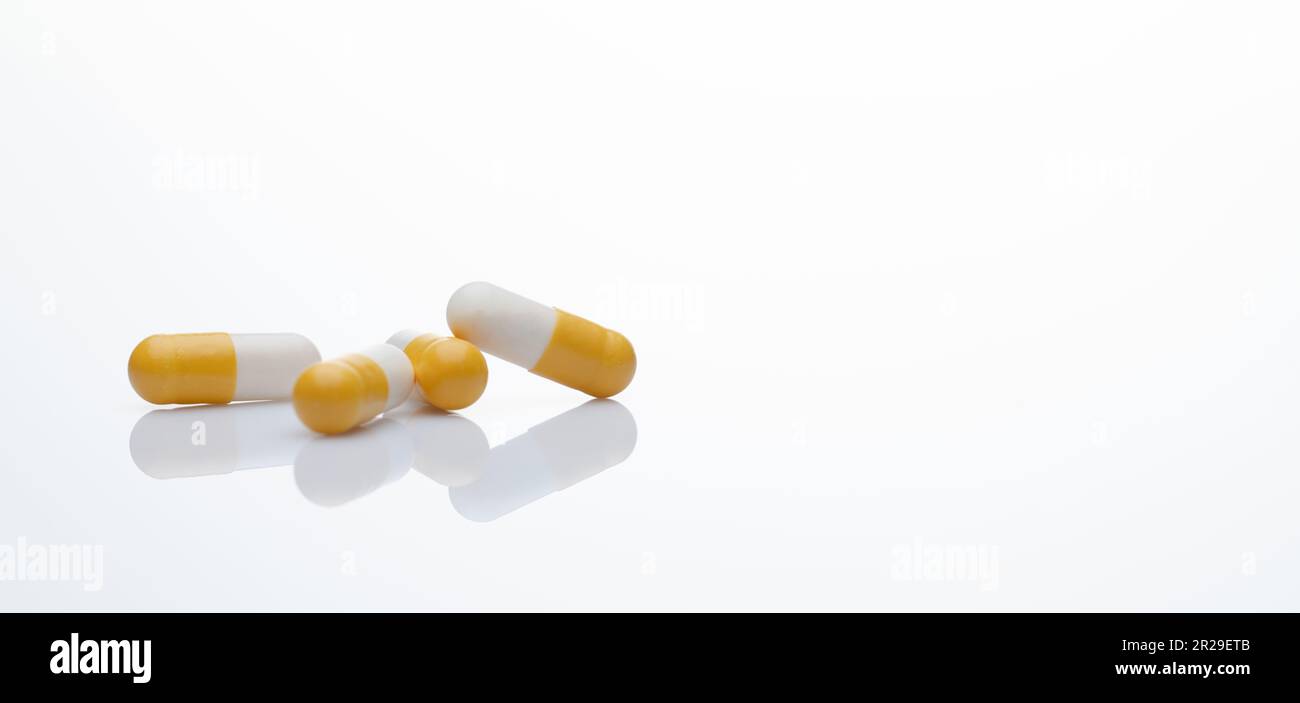 Yellow-white probiotic capsule pill on white background. Probiotic ...