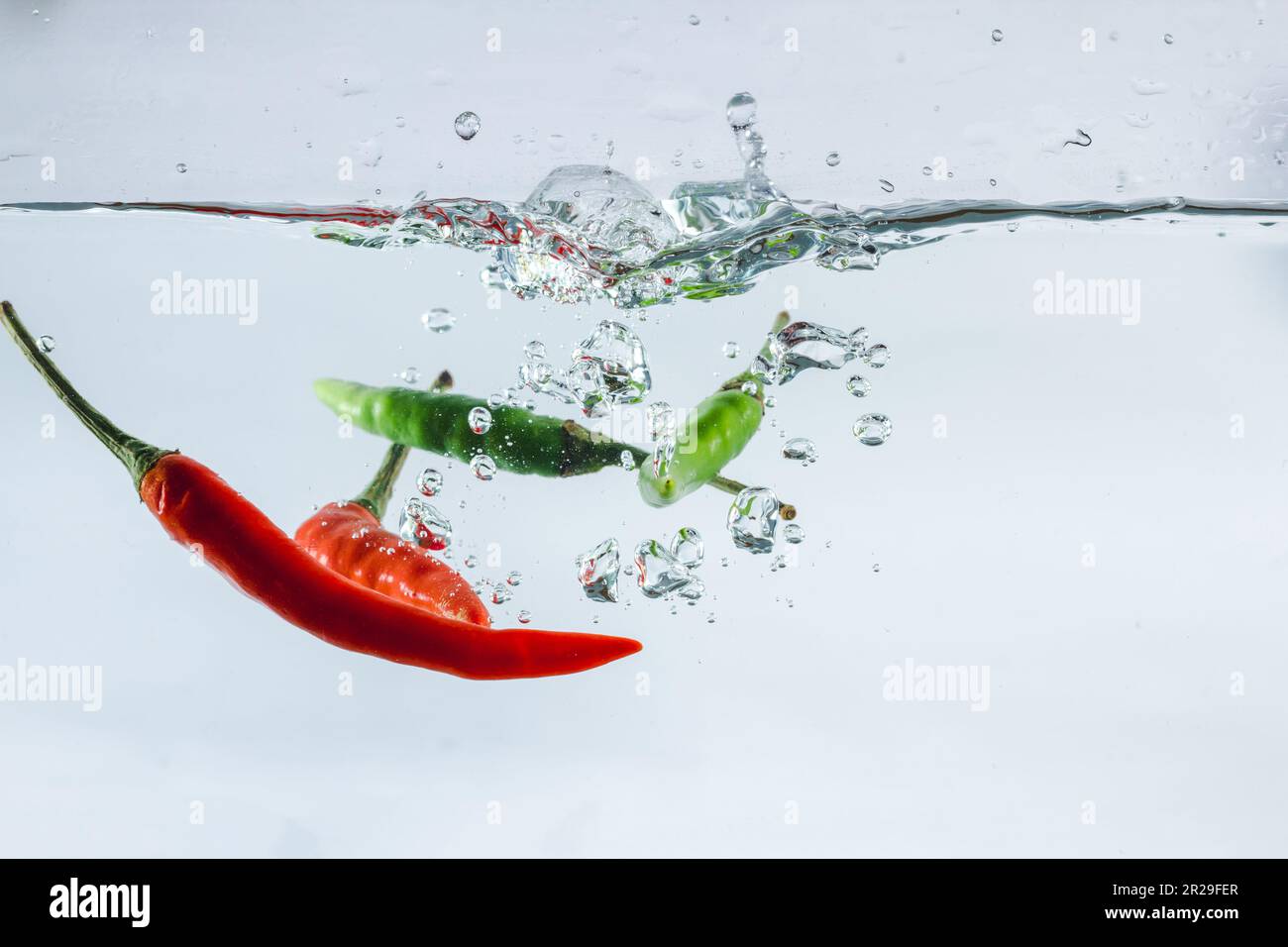 chilli drop water splashes Stock Photo - Alamy