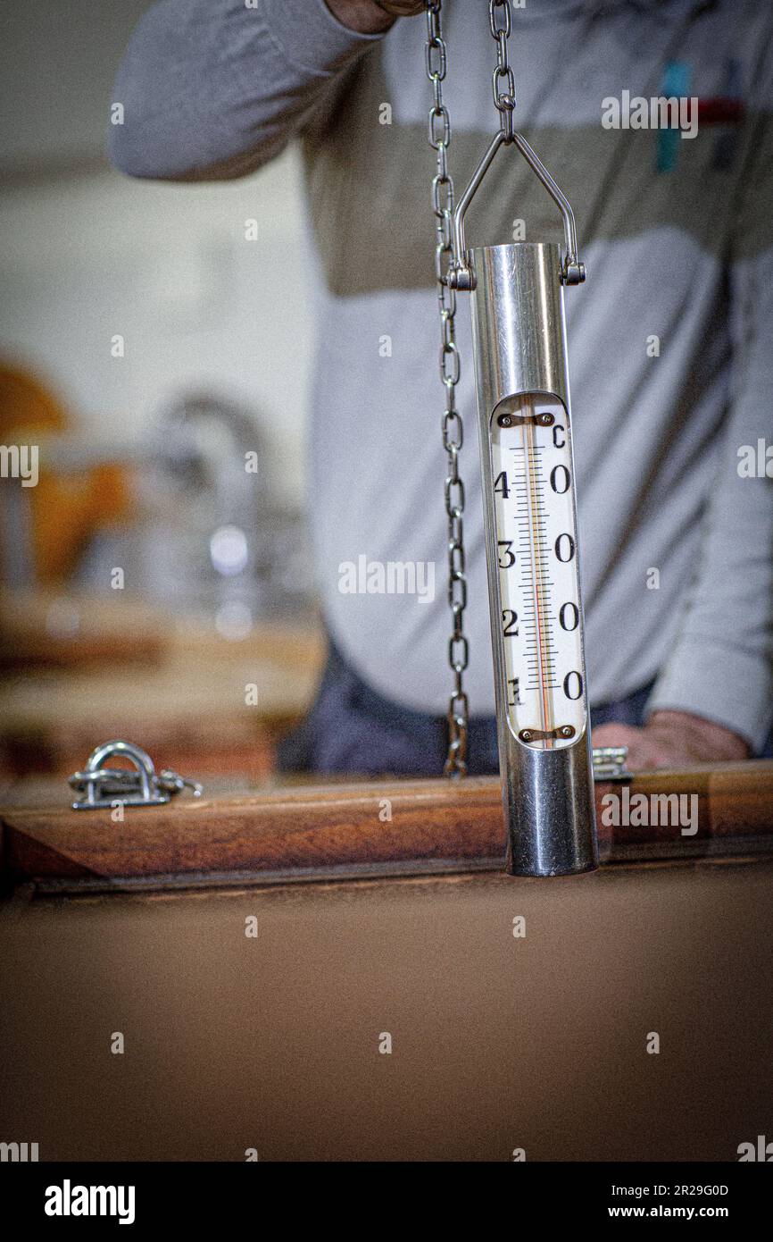 Isle of Harris - distiller checks fermentation with thermometer inside ...