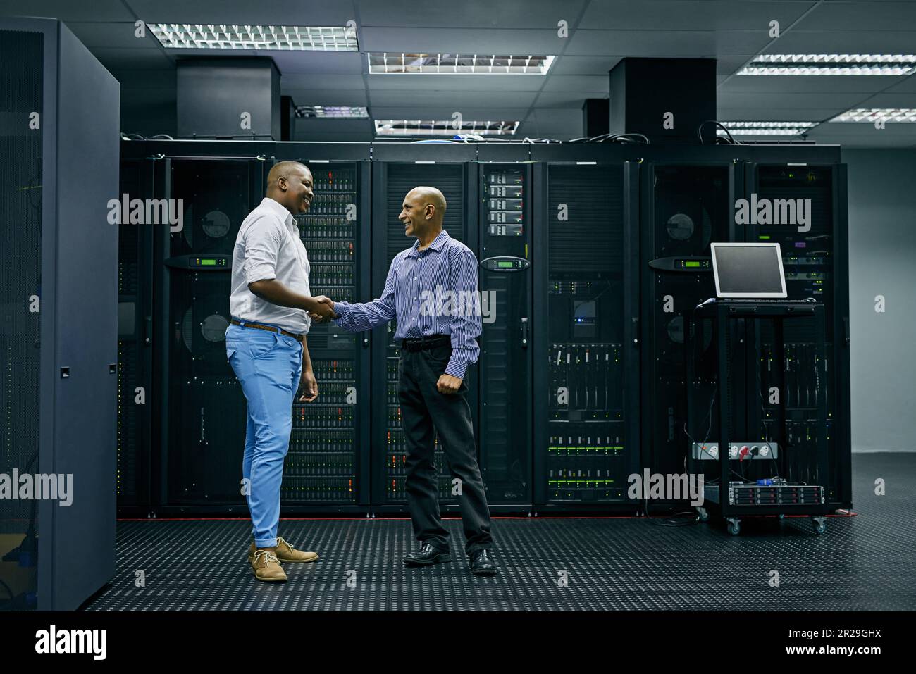 Handshake, partnership or men in server room of data center worker with ...