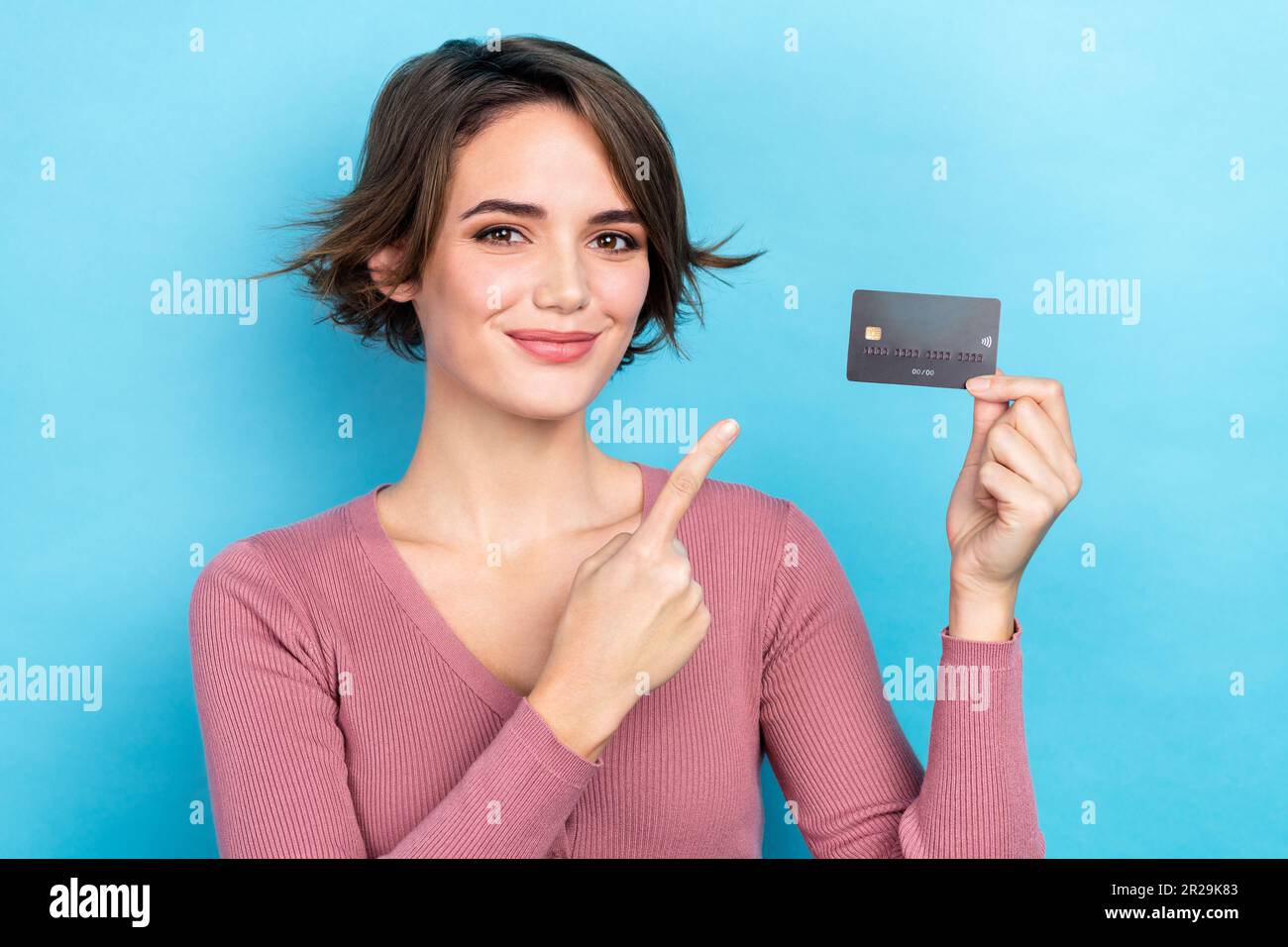 Portrait of gorgeous nice lady indicate finger arm hold debit card ...