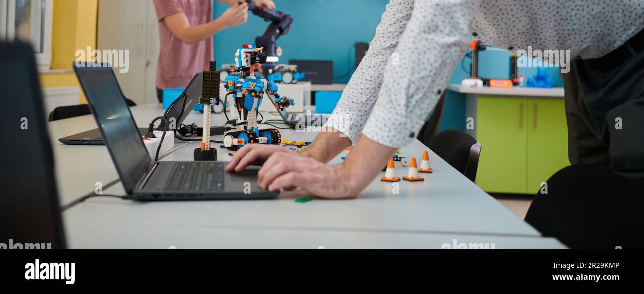 A student testing his new invention of a robotic arm in the laboratory ...