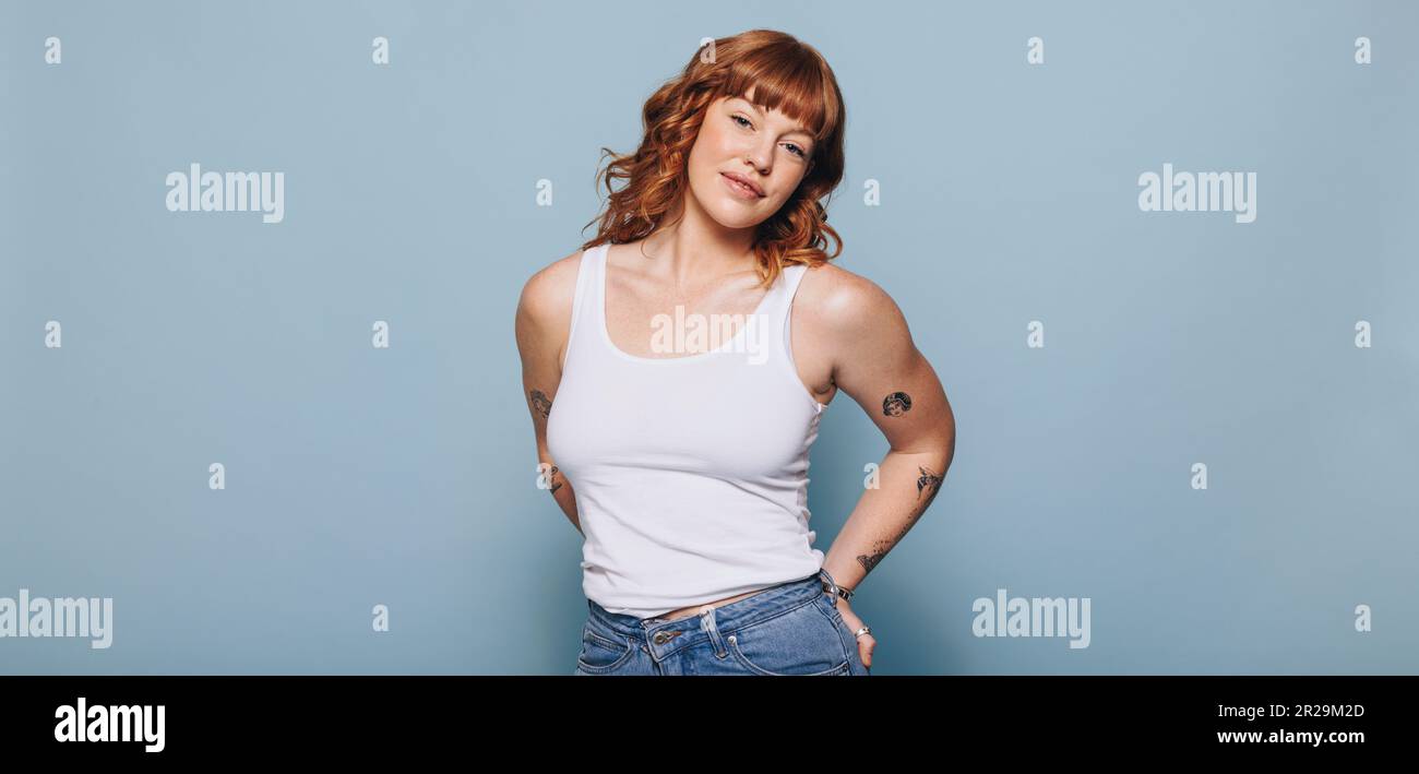 Portrait of a woman with ginger hair looking at the camera while ...