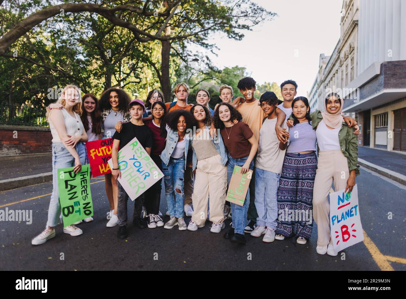 Group of diverse teenage activists smiling cheerfully while standing ...