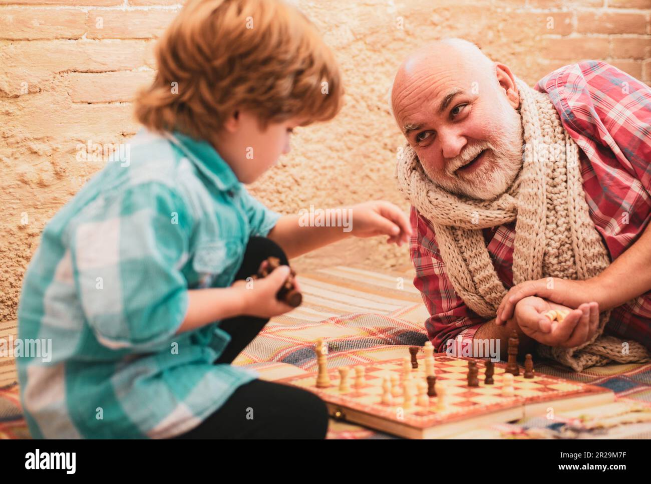 Grandfather playing chess with his grandson. Grandfather and grandson ...