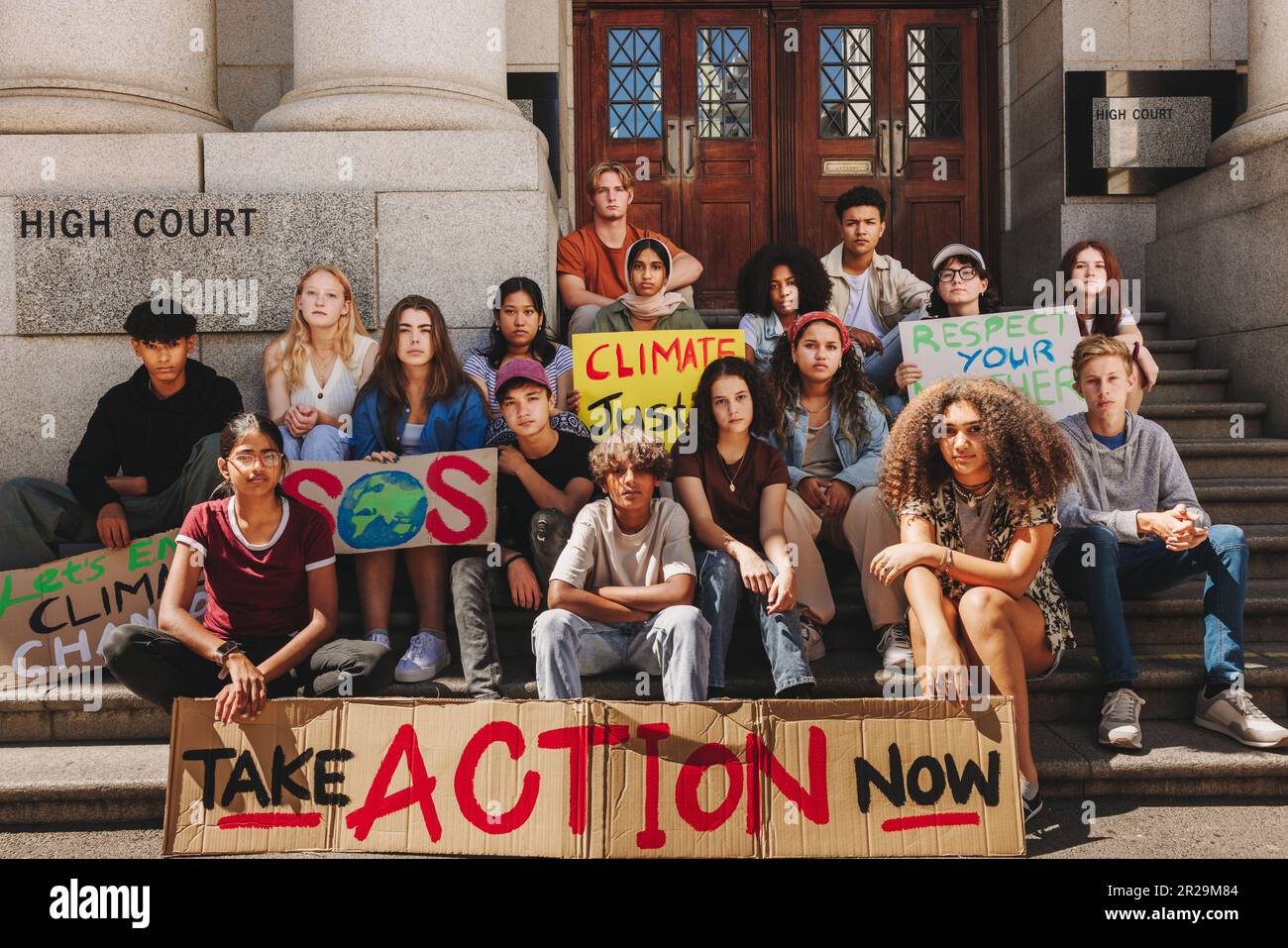Group of climate change activists looking at the camera while sitting ...