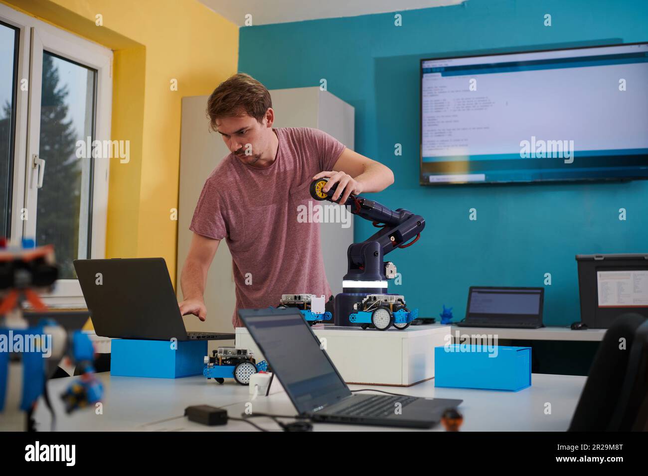 A student testing his new invention of a robotic arm in the laboratory ...