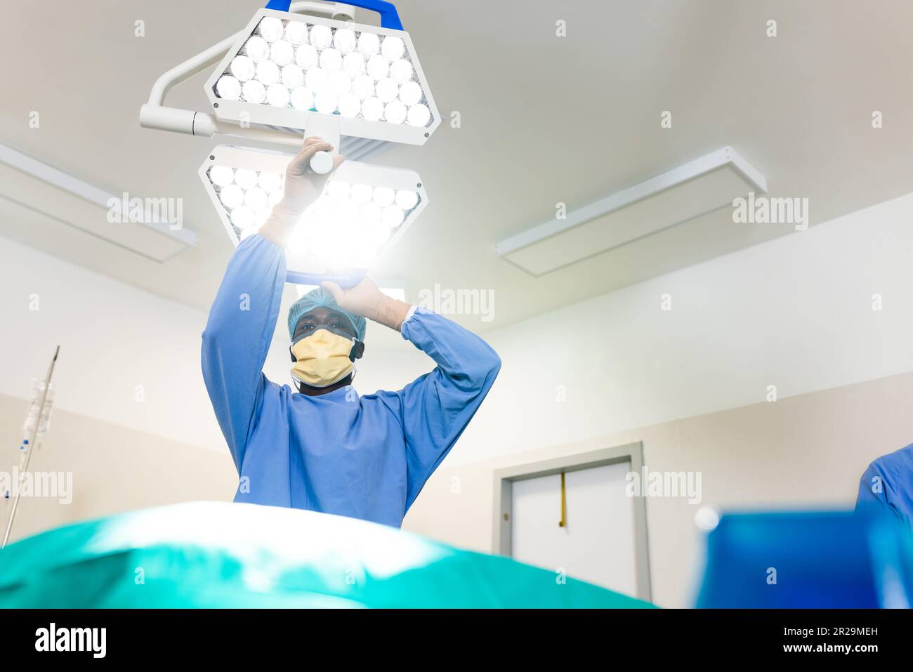 African american male surgeon adjusting light before operation in ...