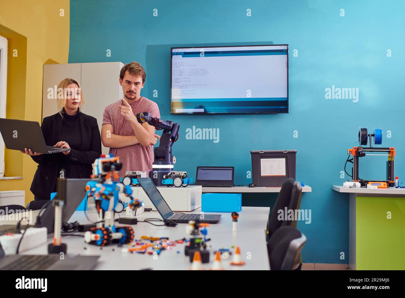 A group of colleagues working together in a robotics laboratory ...