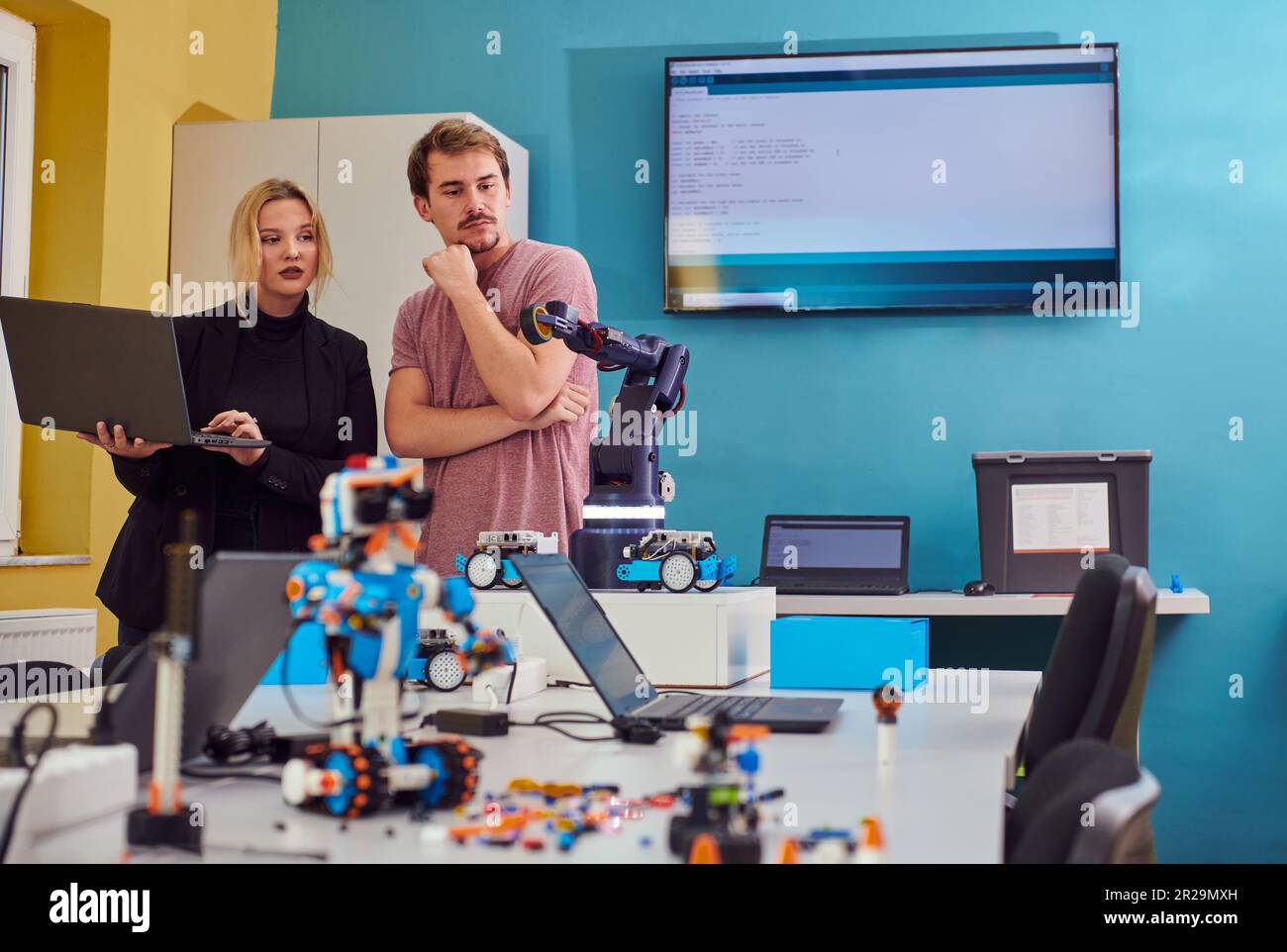 A group of colleagues working together in a robotics laboratory ...