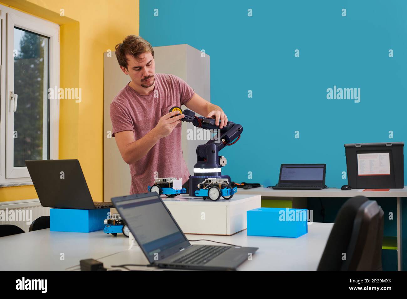 A student testing his new invention of a robotic arm in the laboratory ...