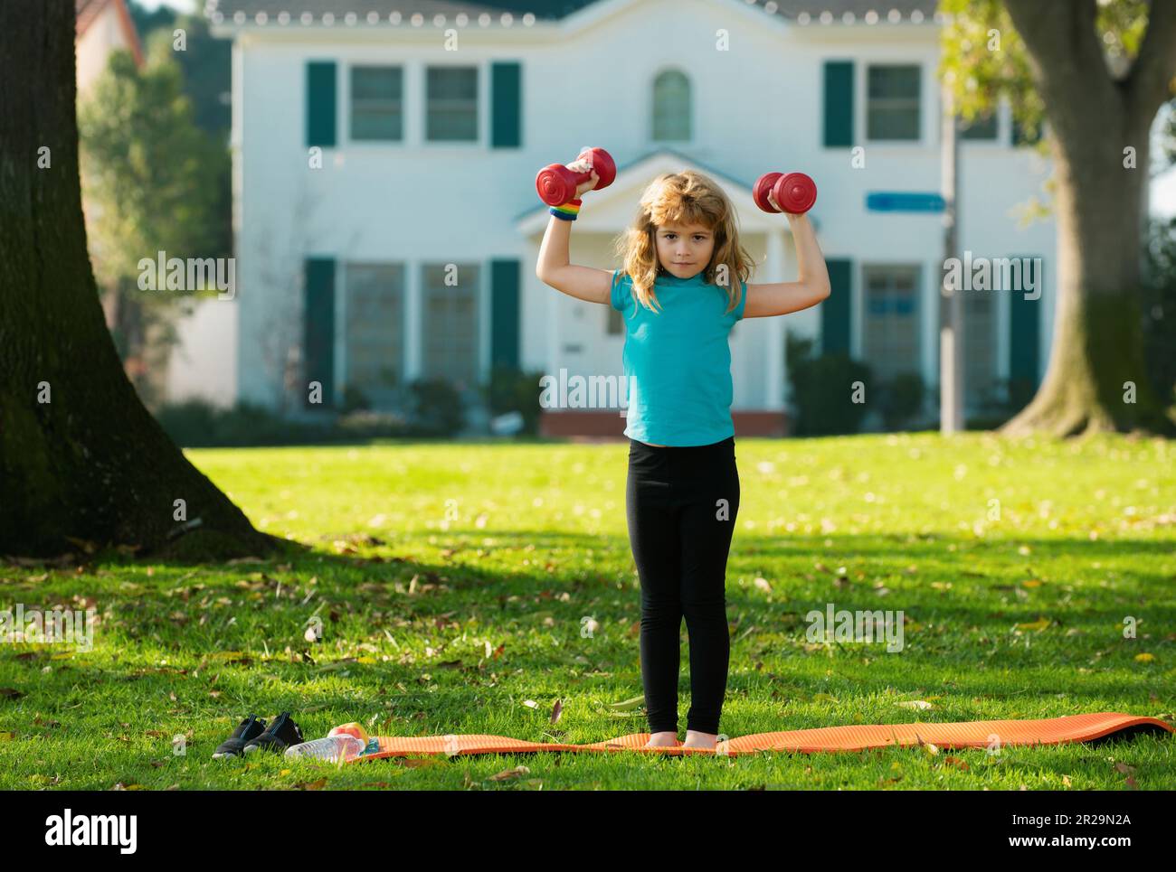 Child boy working out with dumbbells on park background. Kids sport ...