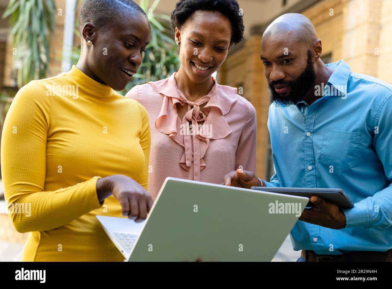 Happy african american colleagues discussing project ideas over laptop ...