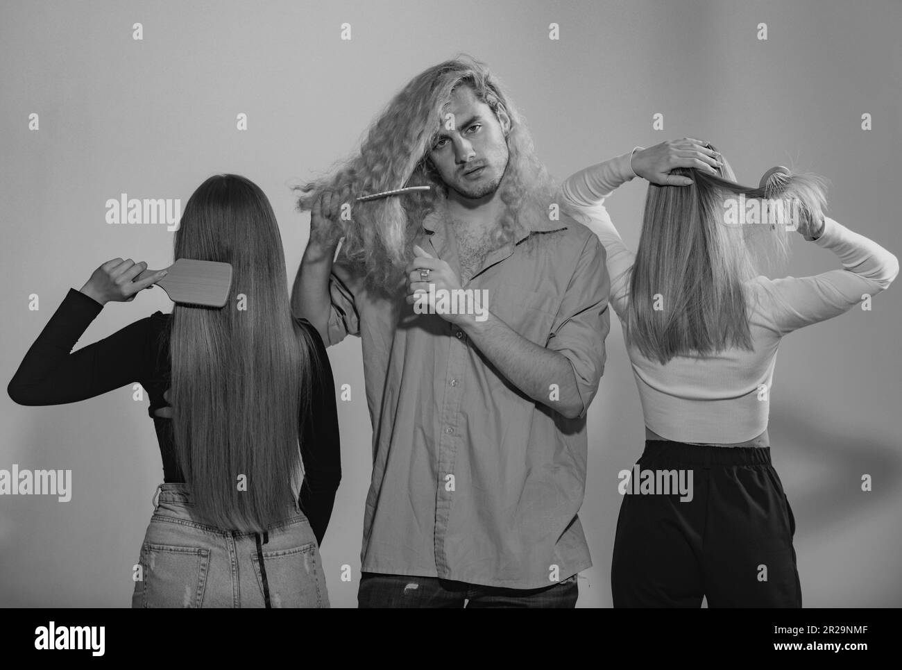 Man brushing curly hair, woman combing straight hair. Group of young ...