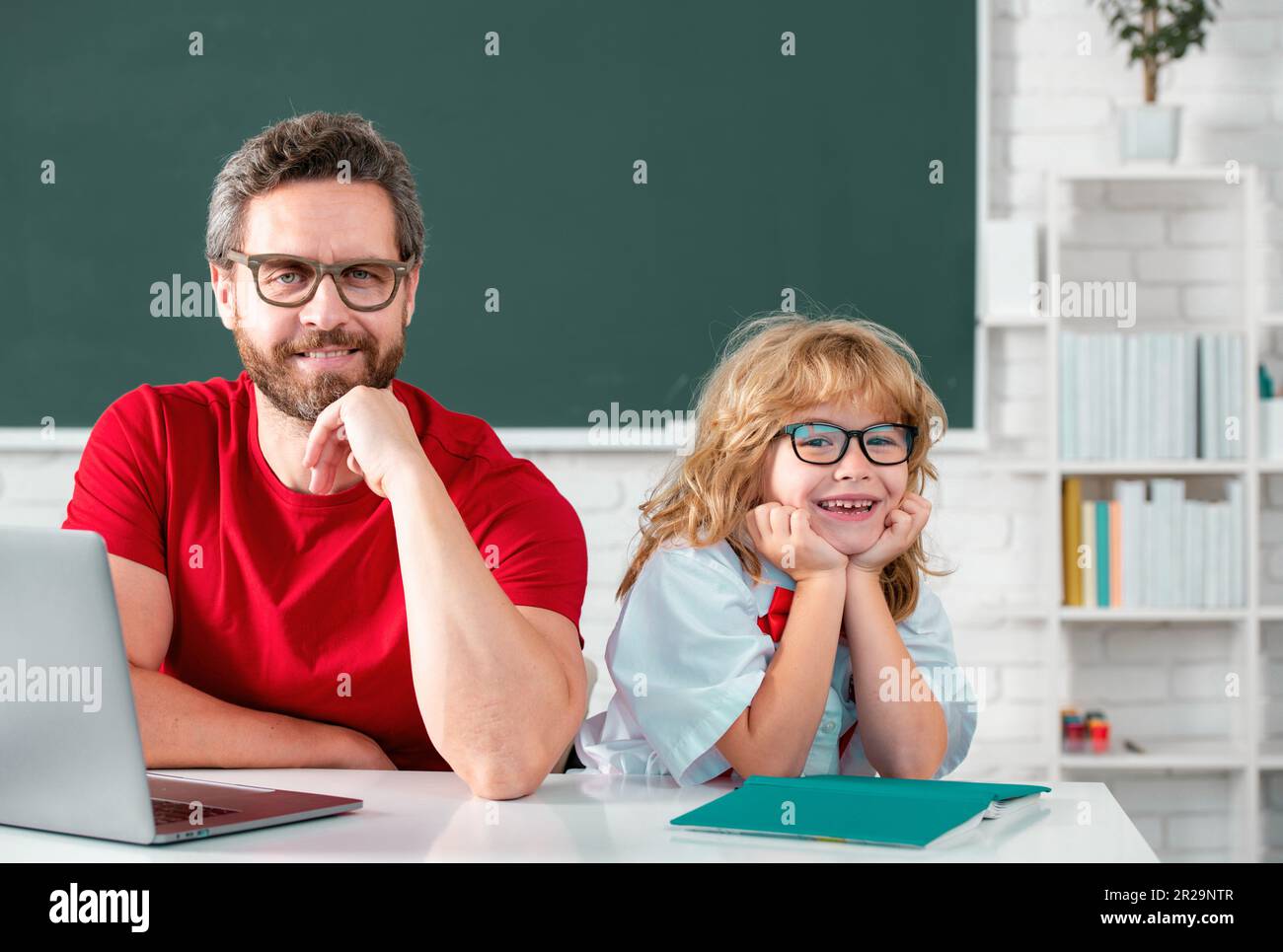 Pupil of primary elementary school has lesson. Kid boy with teacher ...