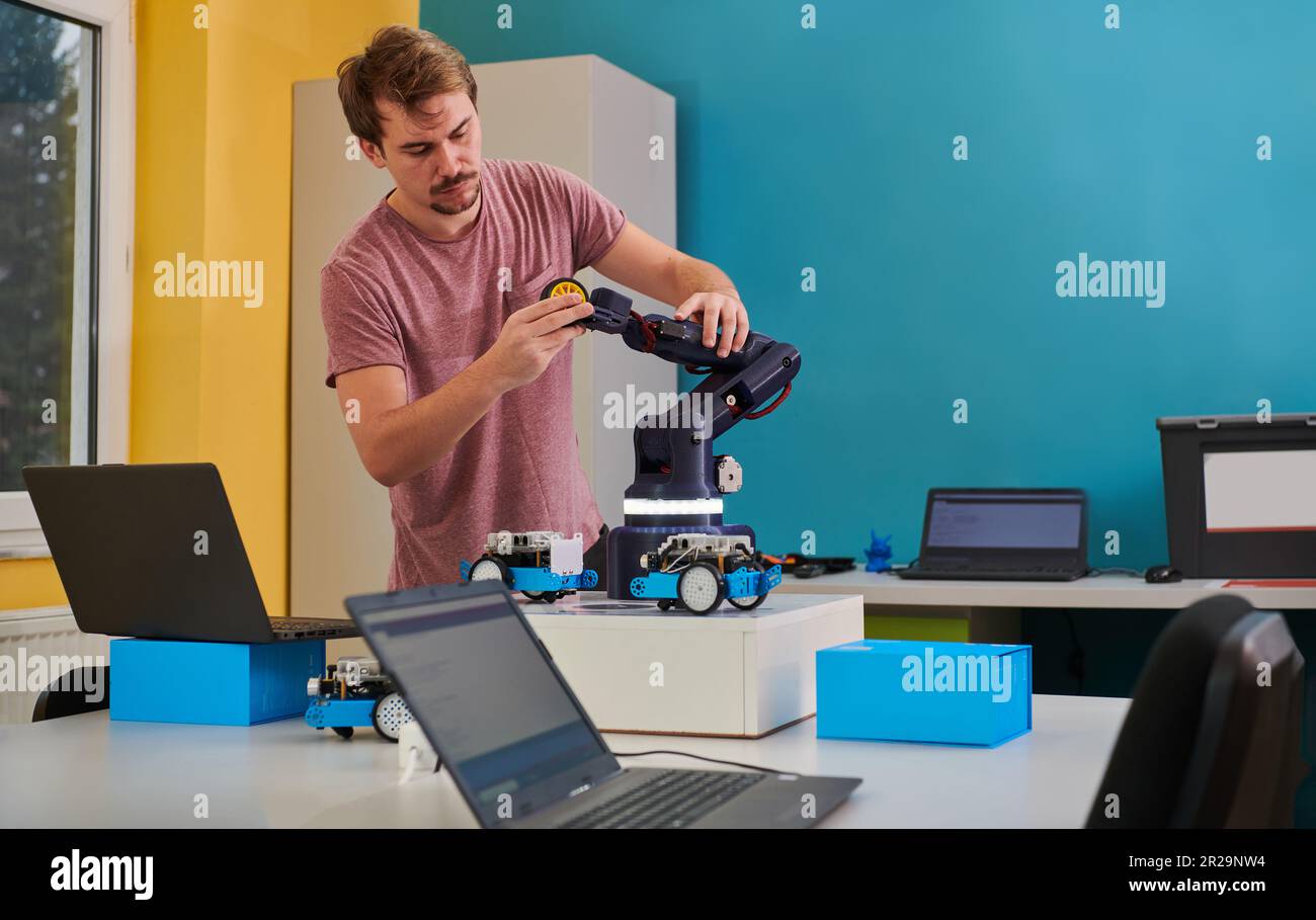 A student testing his new invention of a robotic arm in the laboratory ...