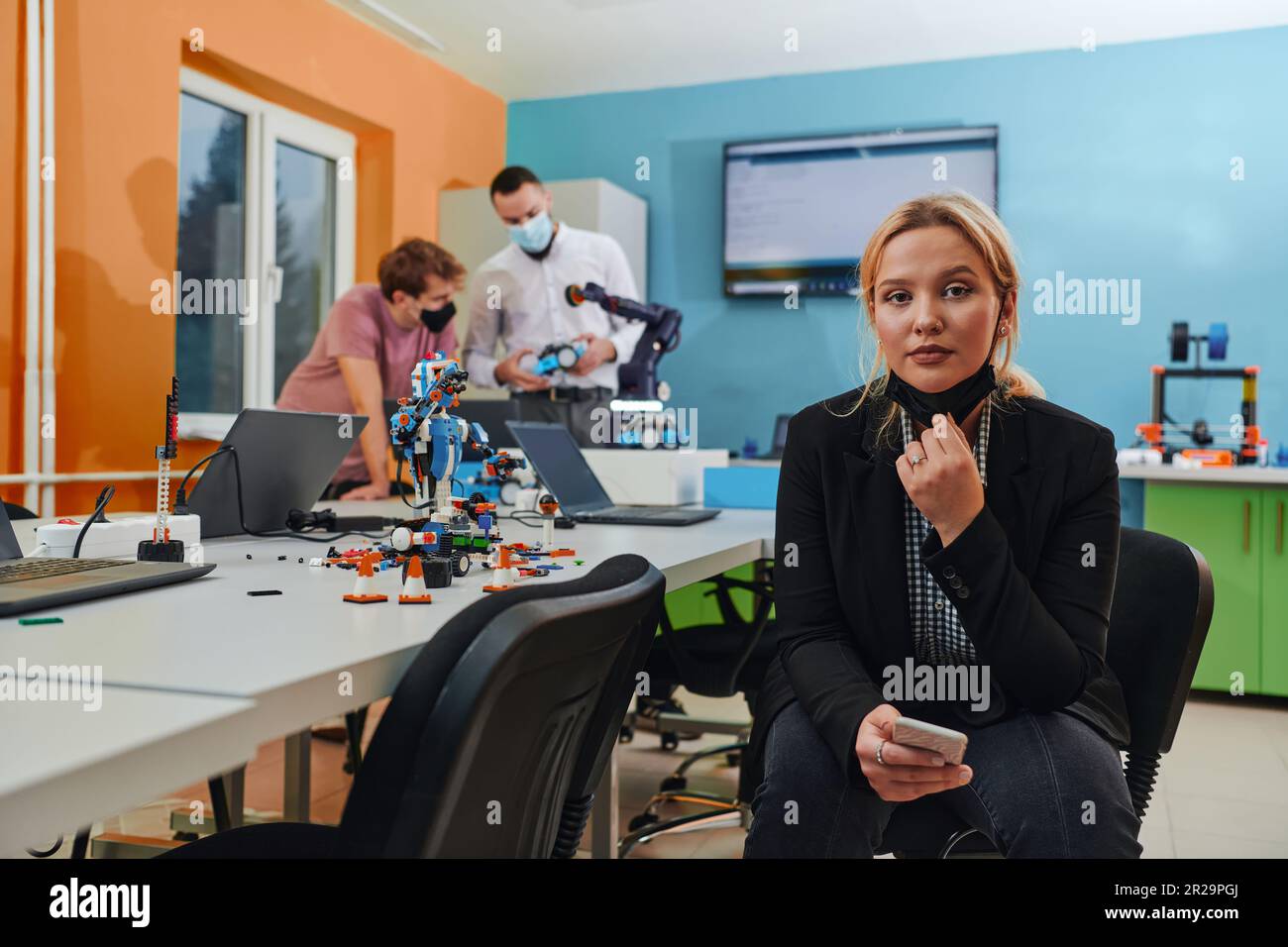 A group of colleagues working together in a robotics laboratory ...