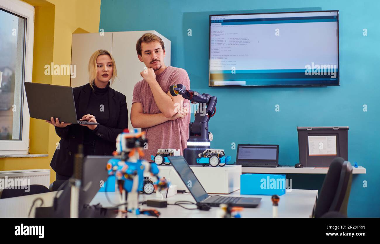 A group of colleagues working together in a robotics laboratory ...
