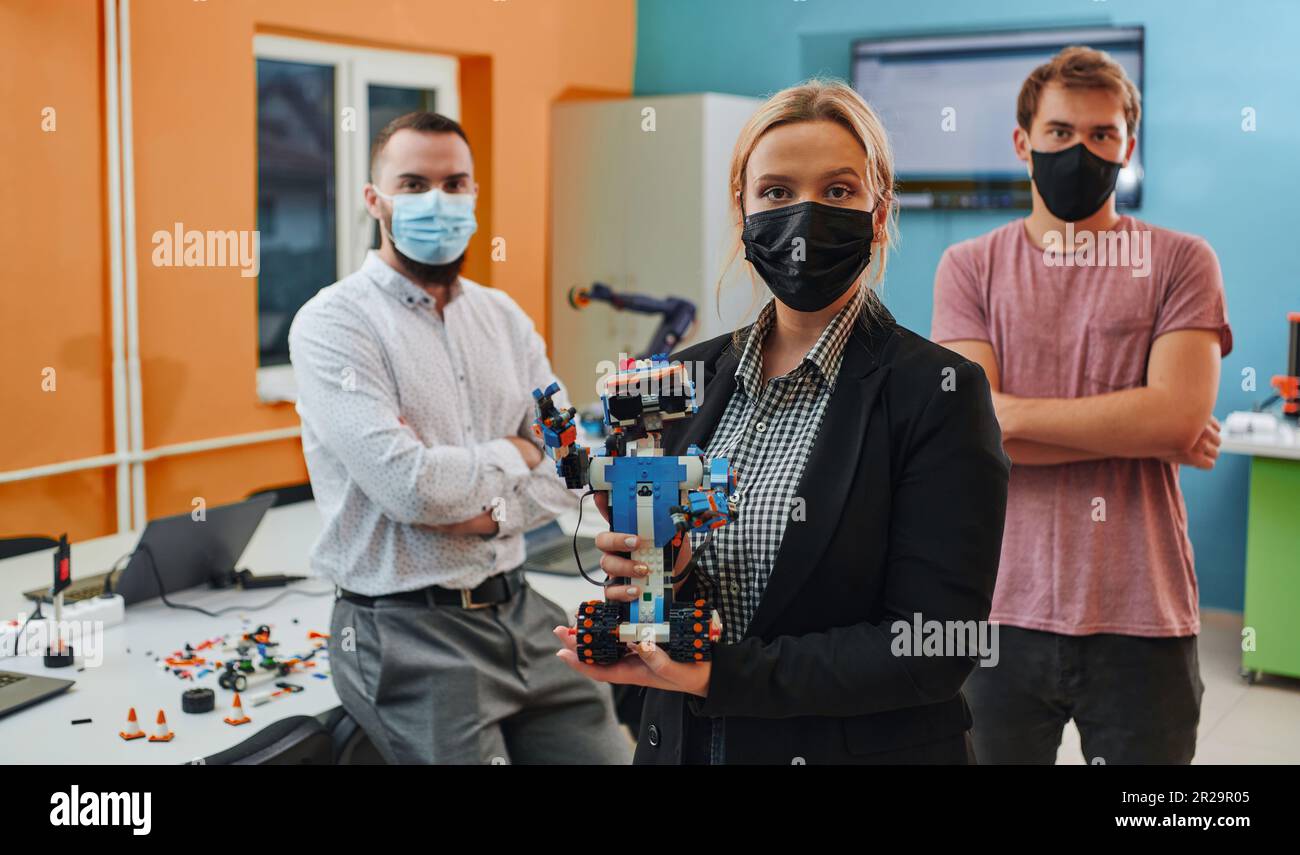 A group of colleagues working together in a robotics laboratory ...