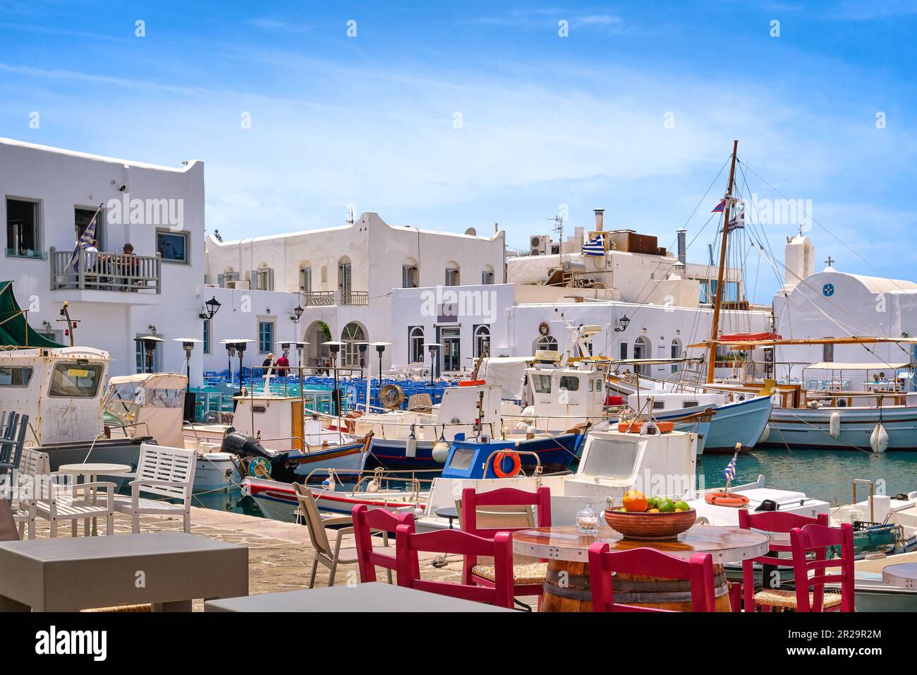 Outdoor dining by waterfront, fishing boat harbour of Naoussa, Paros ...
