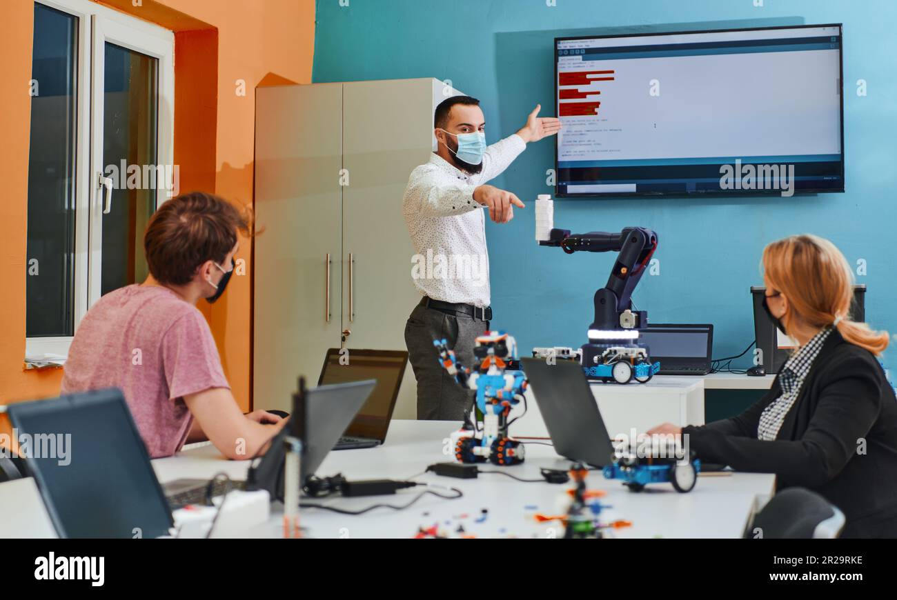 A group of colleagues working together in a robotics laboratory ...