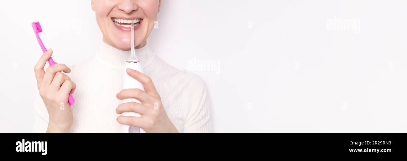 Banner smiling with ideal teeth woman holds oral irrigator, toothbrush ...