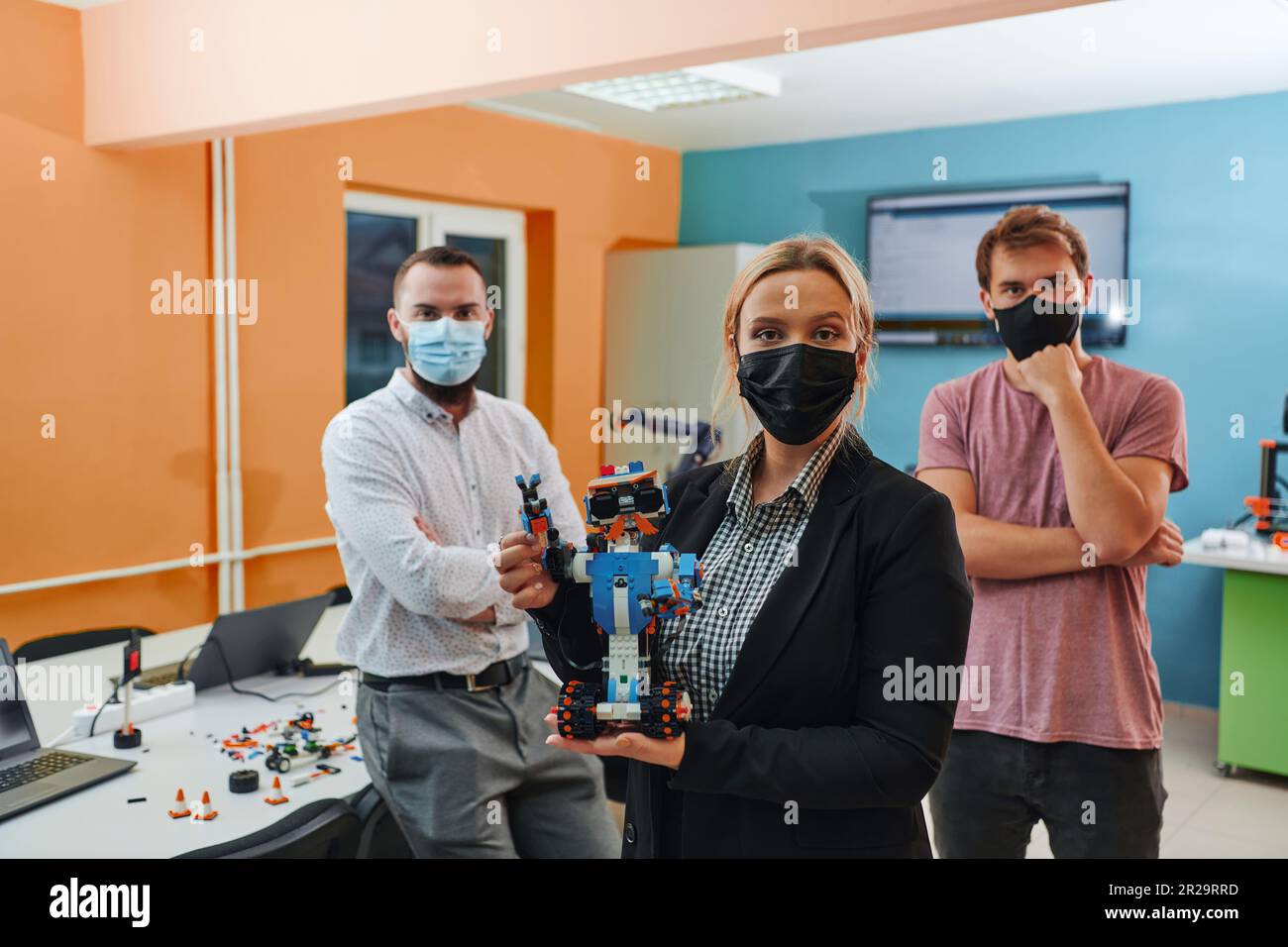 A group of colleagues working together in a robotics laboratory ...