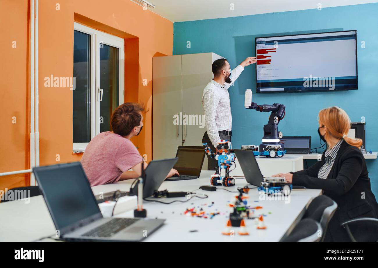 A group of colleagues working together in a robotics laboratory ...