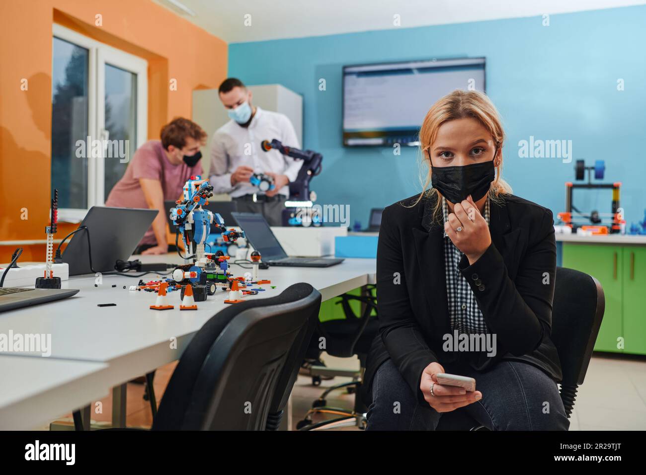 A woman wearing a protective mask standing in a laboratory while her ...