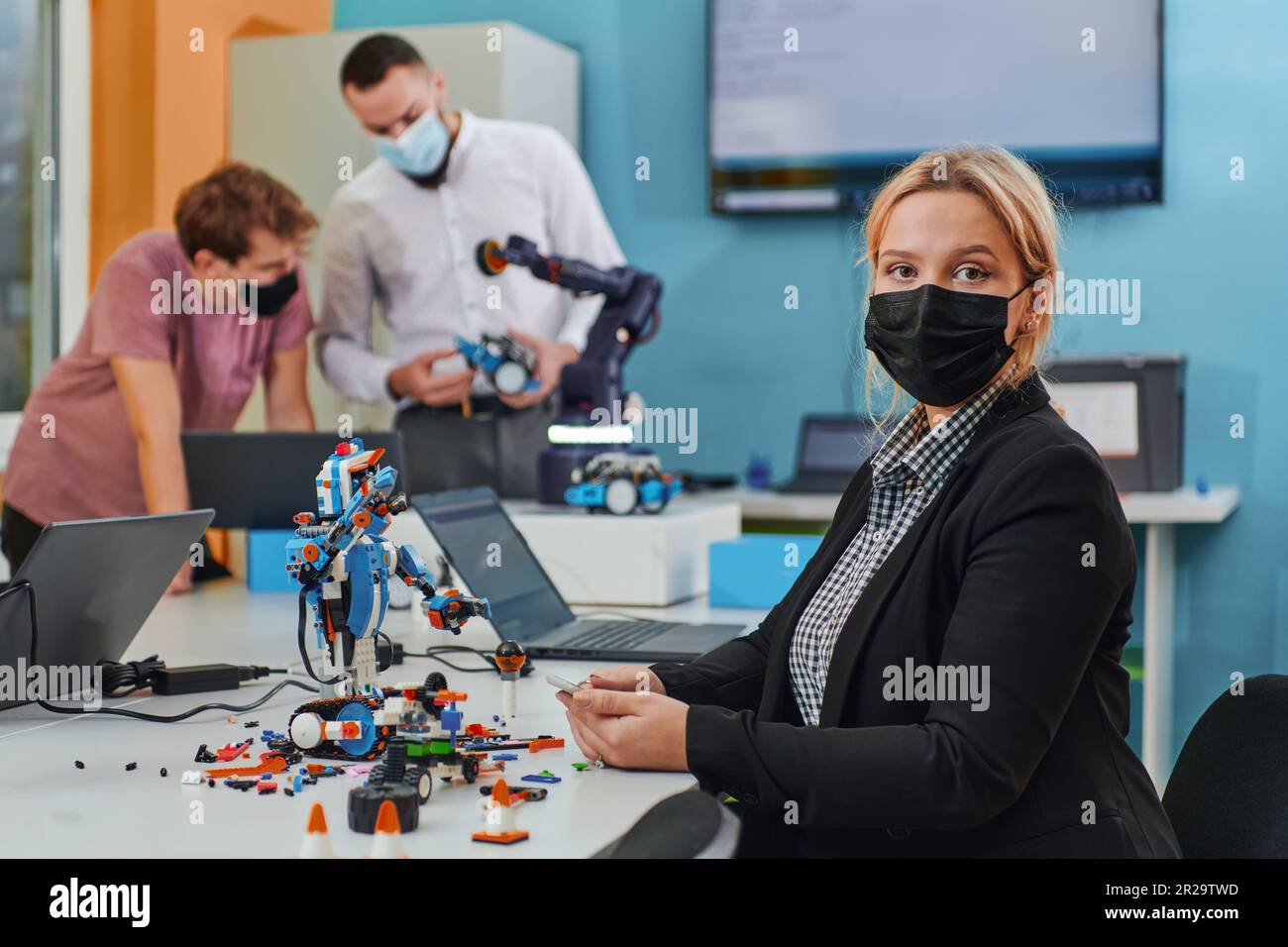 A woman wearing a protective mask standing in a laboratory while her ...