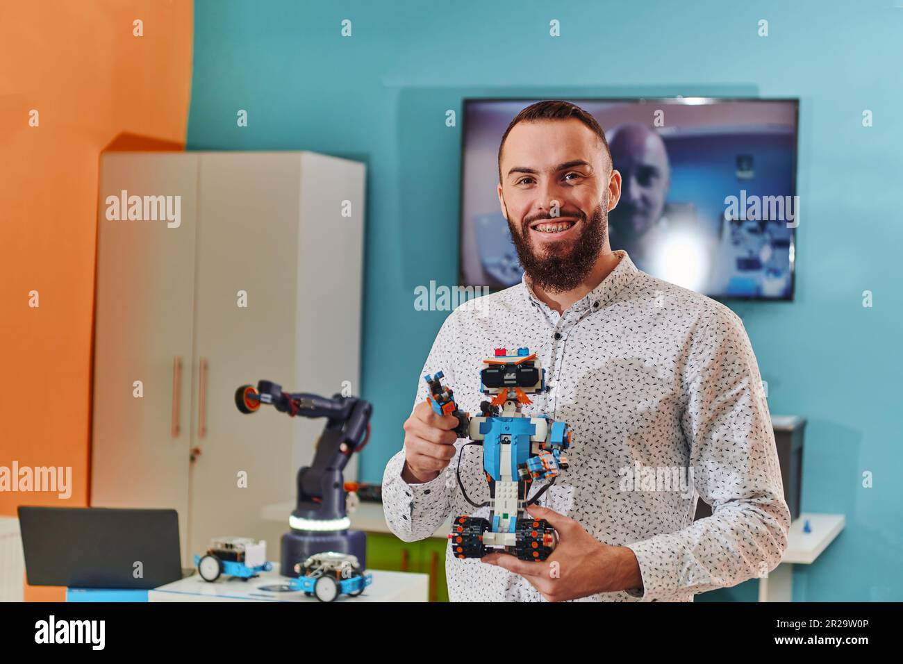 A man working in a robotics laboratory, focusing on the intricate ...