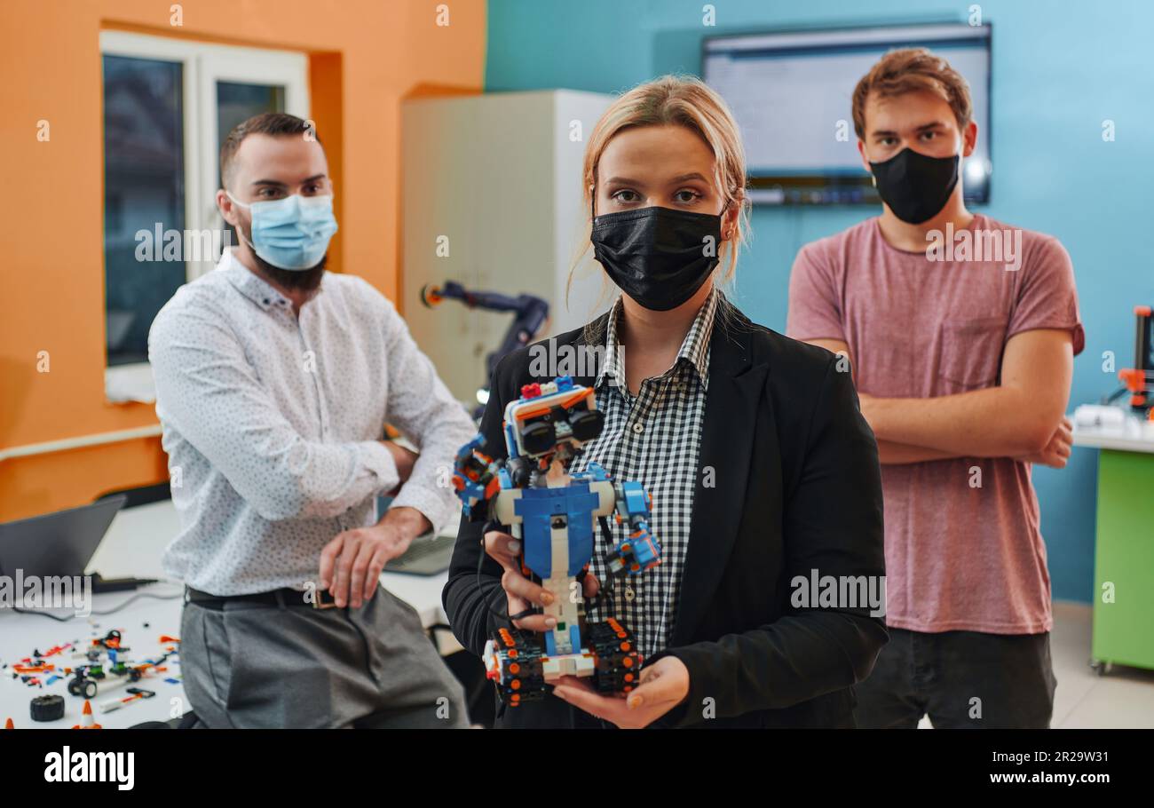 A group of colleagues working together in a robotics laboratory ...