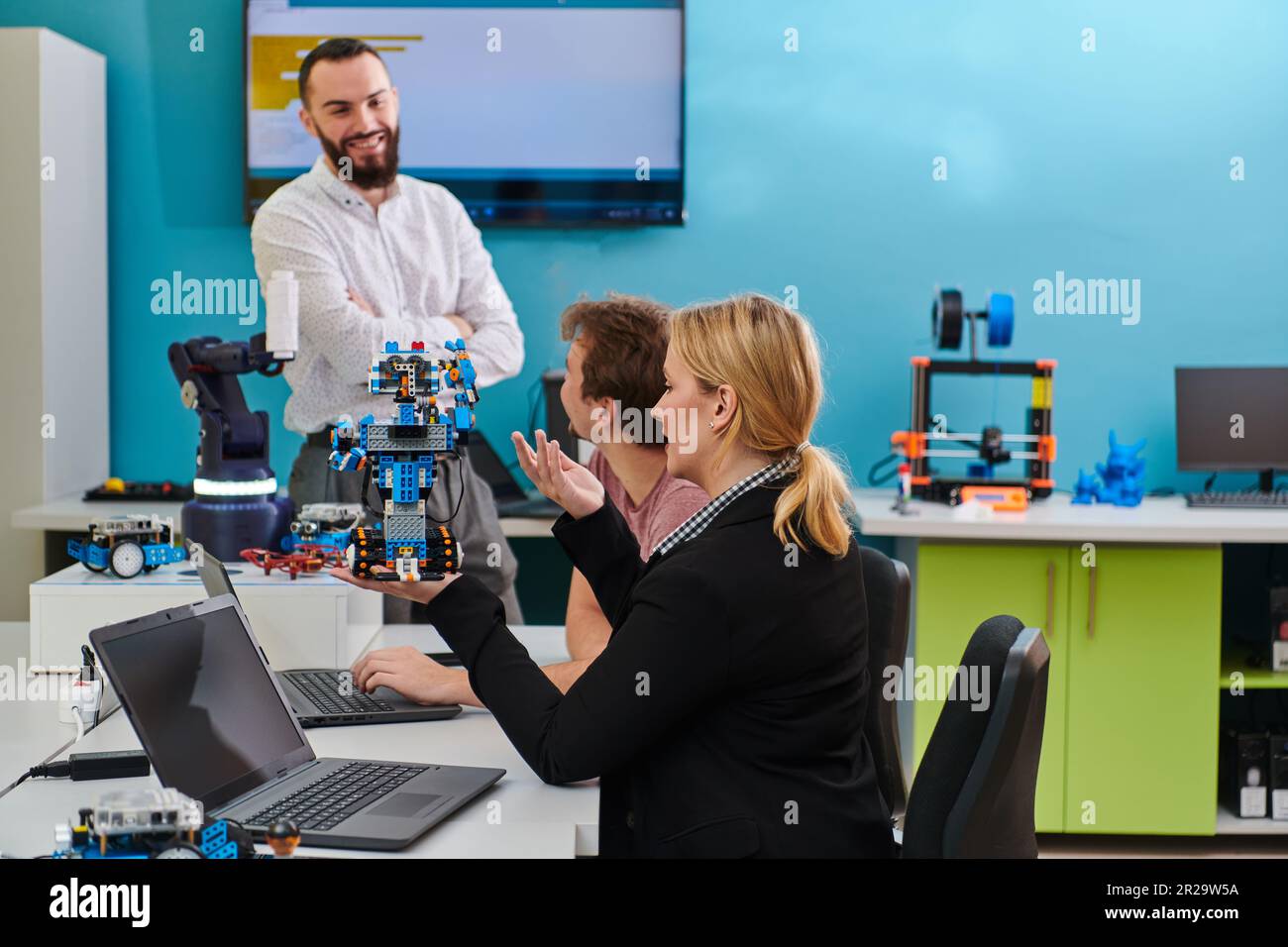 A group of colleagues working together in a robotics laboratory ...