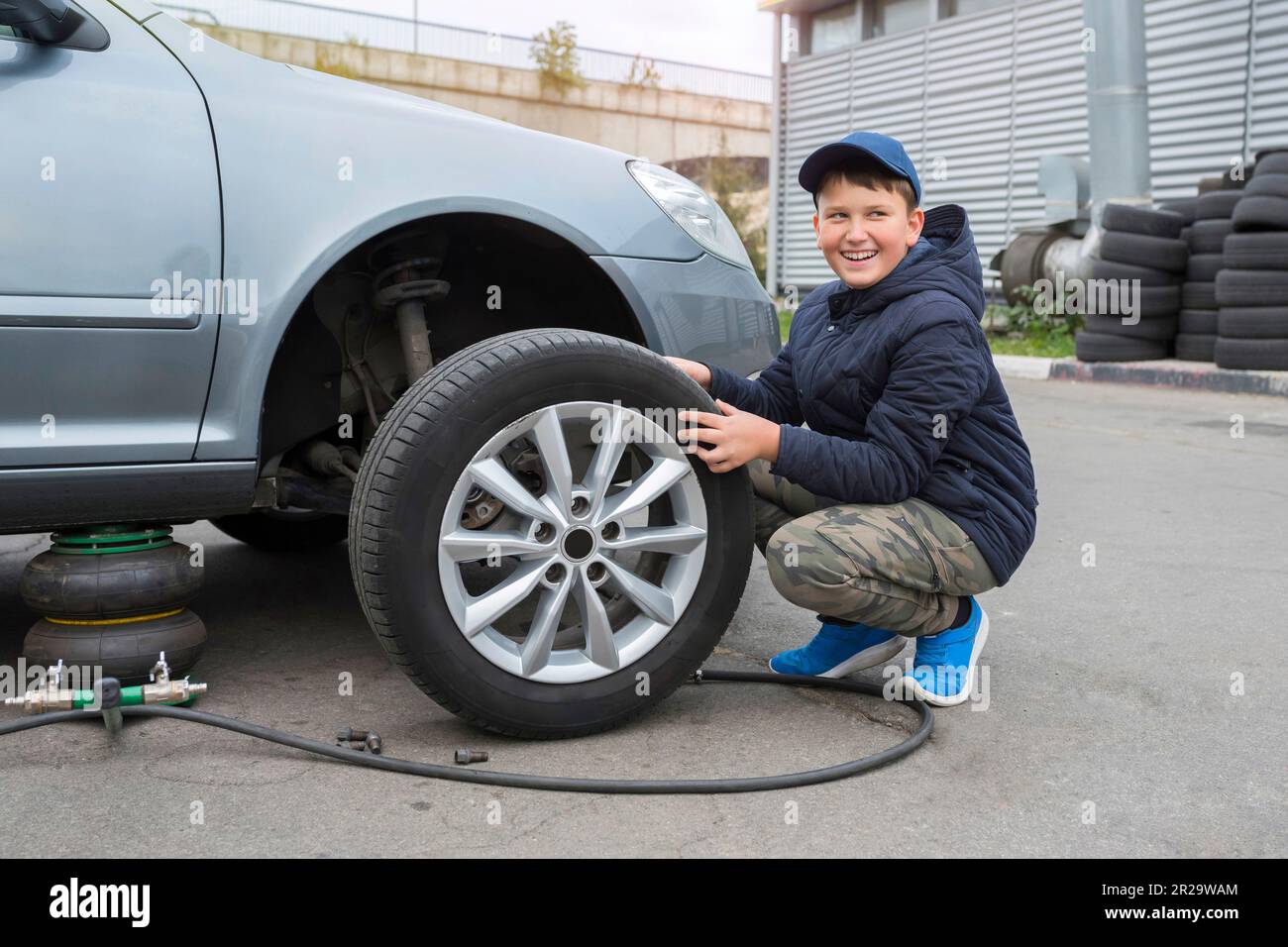 Children's auto mechanic changes the wheel on a car. Wheel repair Stock ...