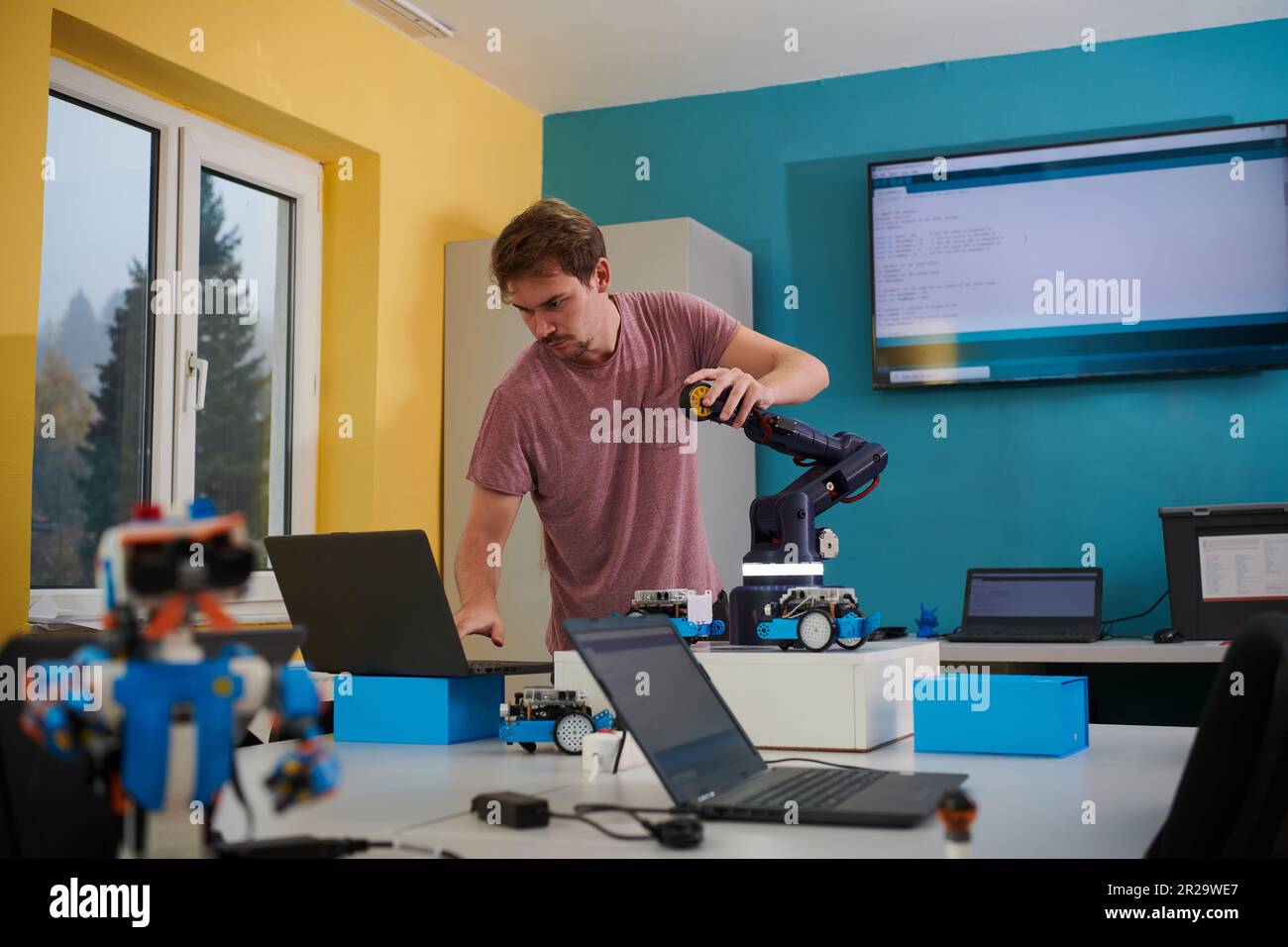 A student testing his new invention of a robotic arm in the laboratory ...